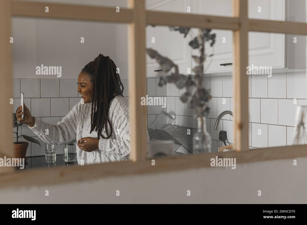 African american woman making video call in kitchen - social networks ...
