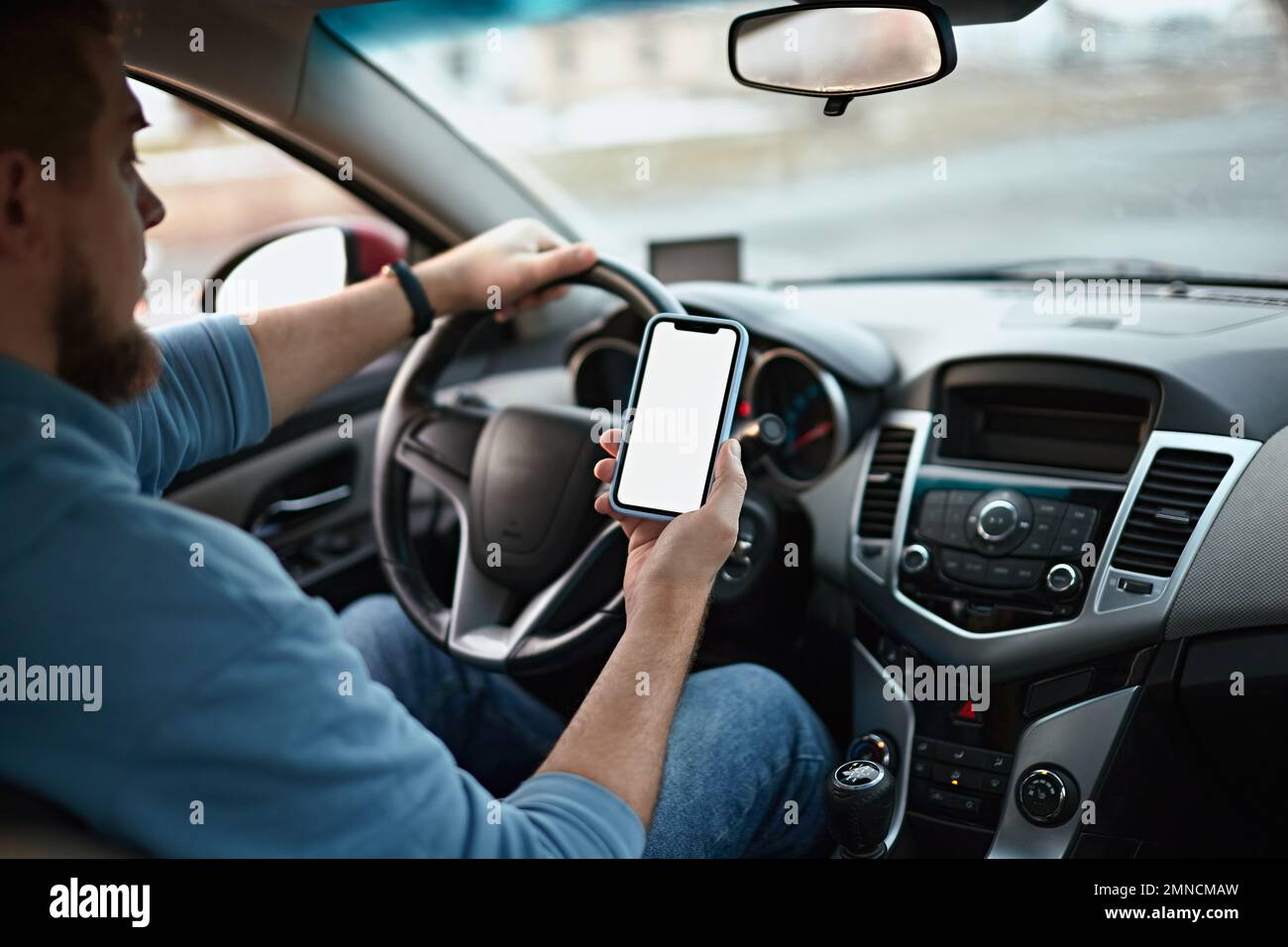 Man driver using mobile phone screen blank mockup on the road while ...