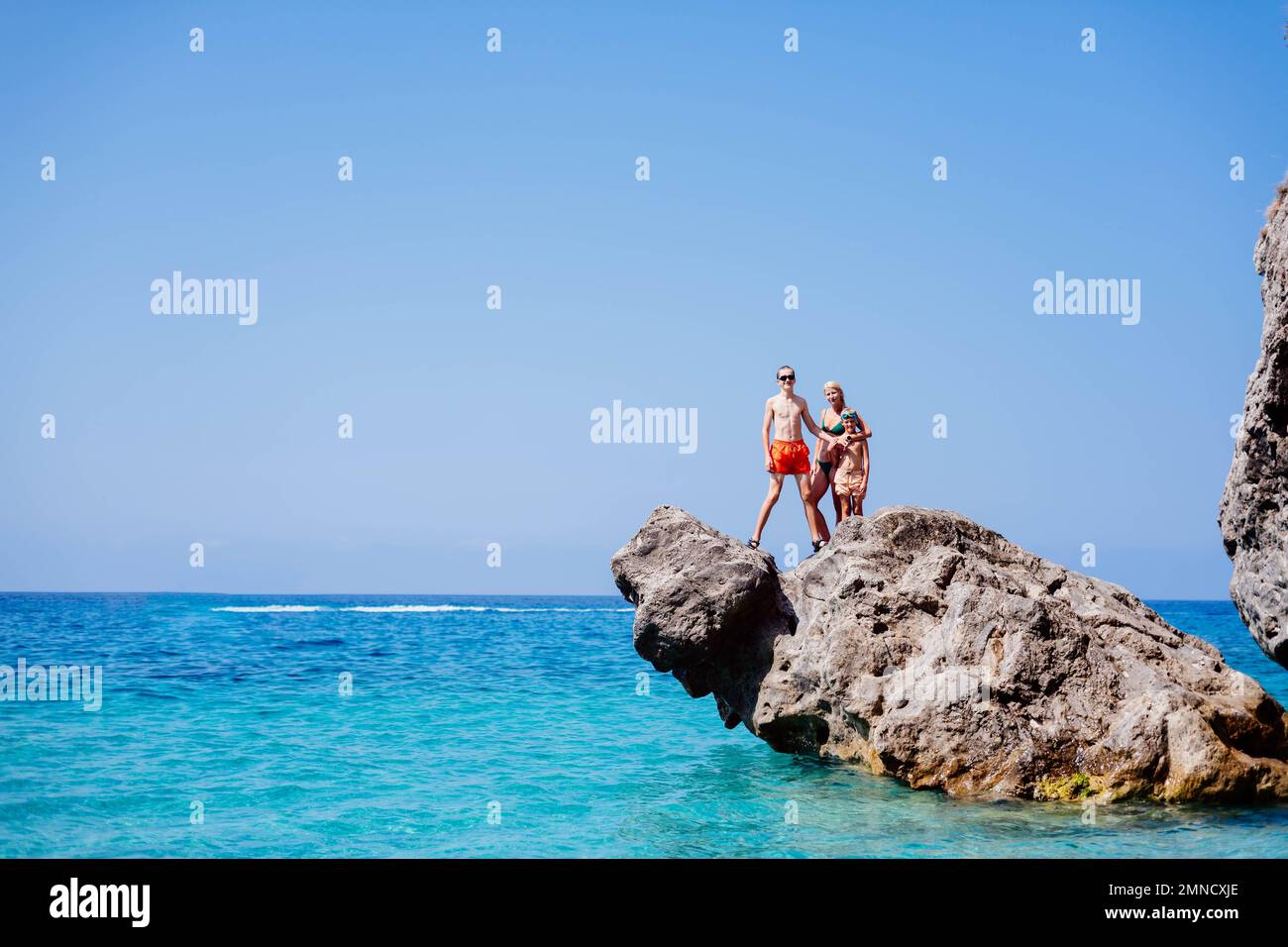 Happy family during vacation on the rock. Mom with two sons Stock Photo ...