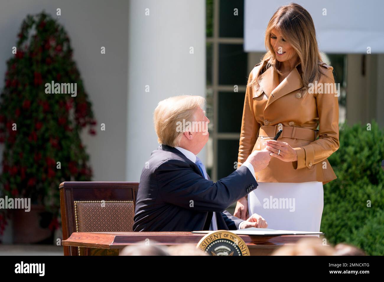 President Donald Trump hands first lady Melania Trump his pen after ...