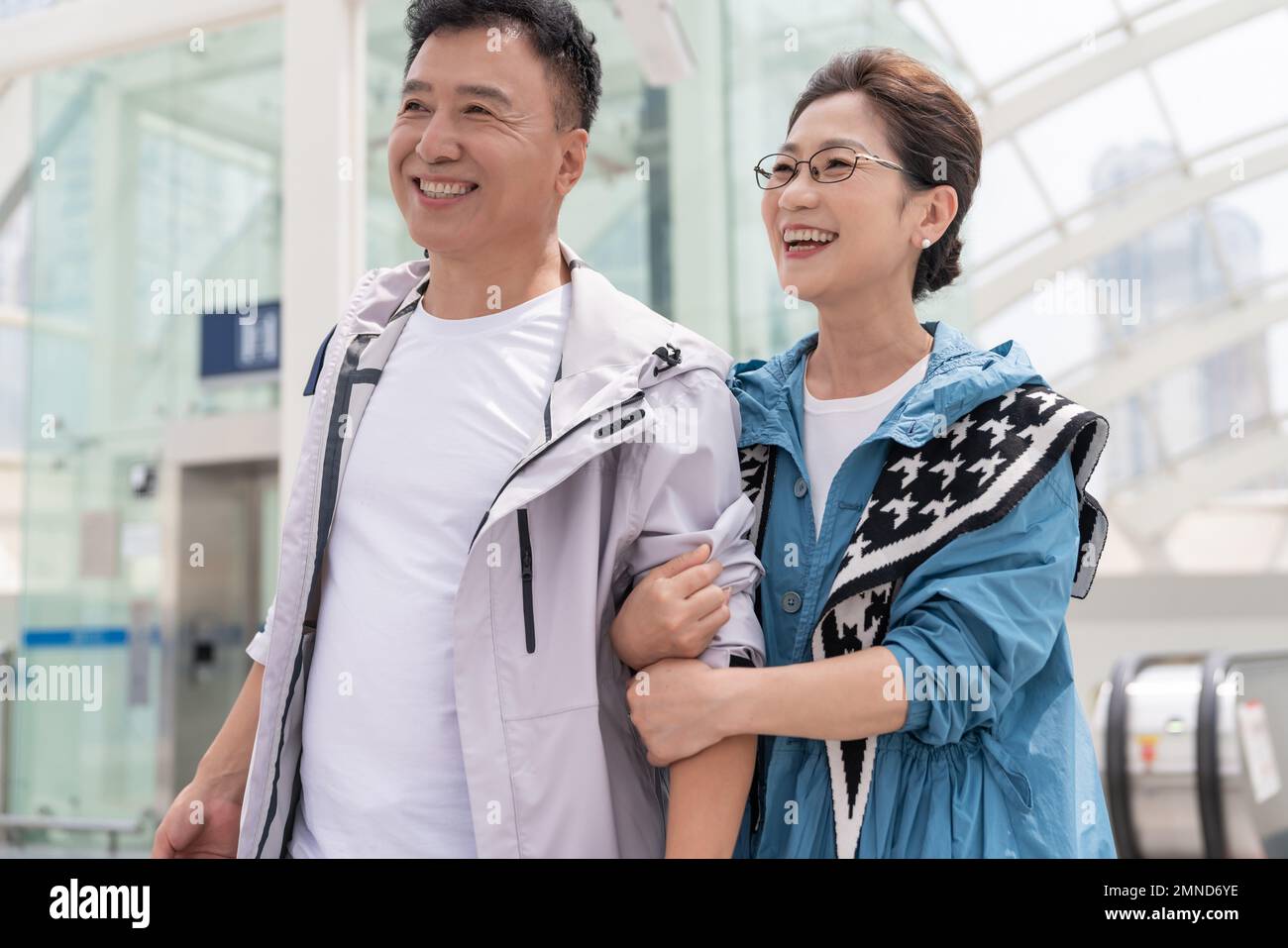Happy elderly couple take the elevator at the airport Stock Photo - Alamy