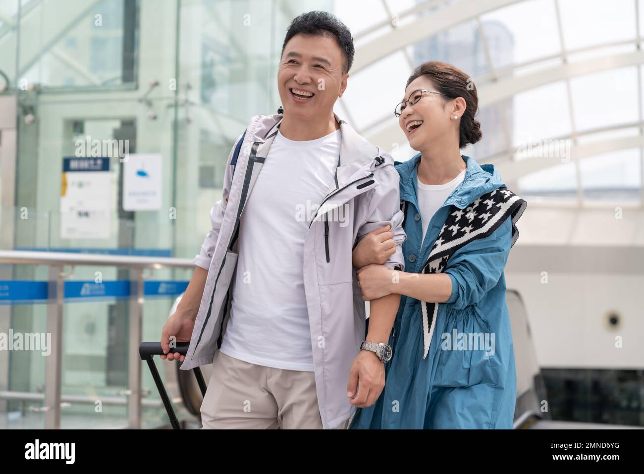 Happy elderly couple take the elevator at the airport Stock Photo - Alamy