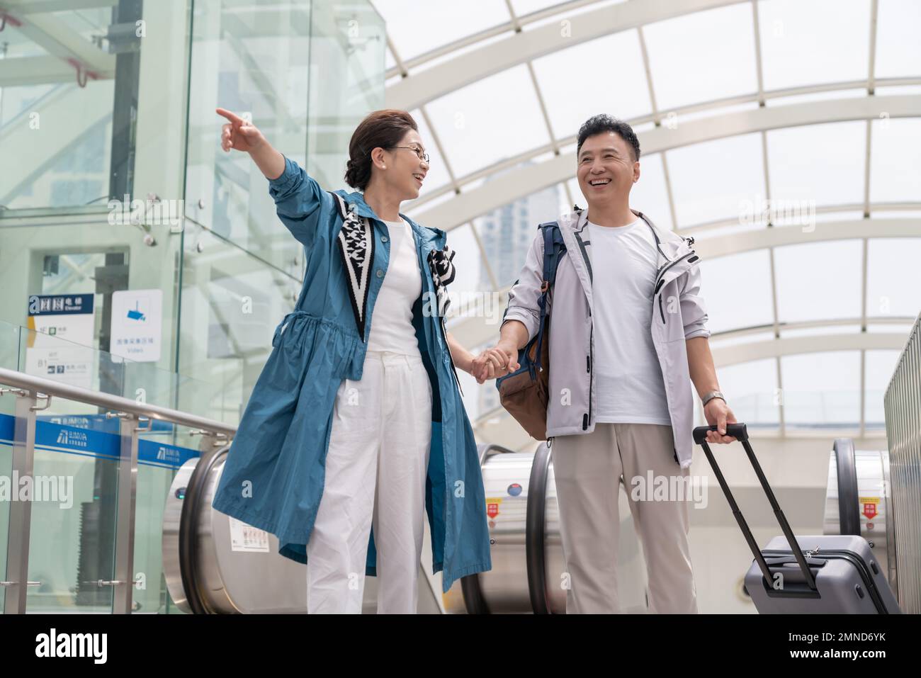 Happy elderly couple take the elevator at the airport Stock Photo - Alamy