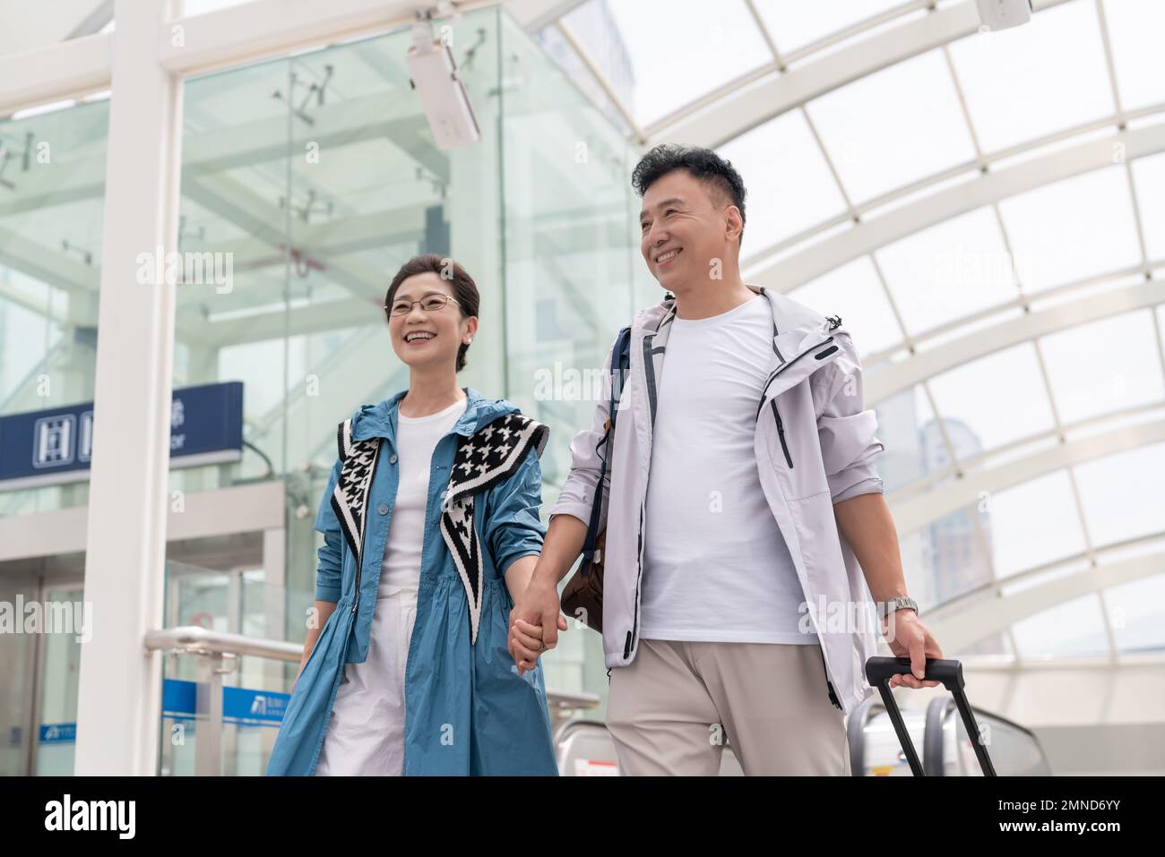 Happy elderly couple take the elevator at the airport Stock Photo - Alamy