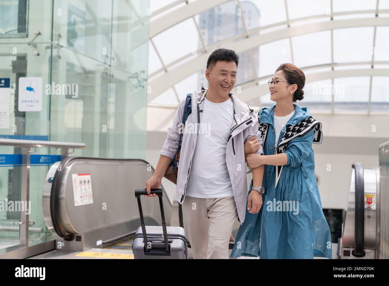 Happy elderly couple take the elevator at the airport Stock Photo - Alamy