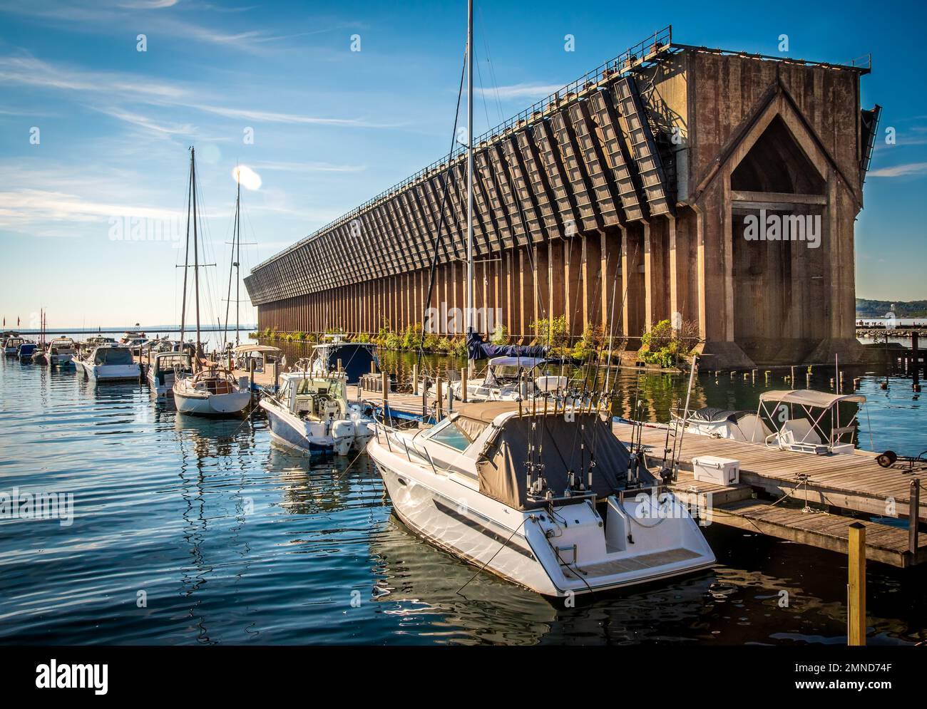 Boat Marina pier with sail boats tied next to old historic iron ore ...
