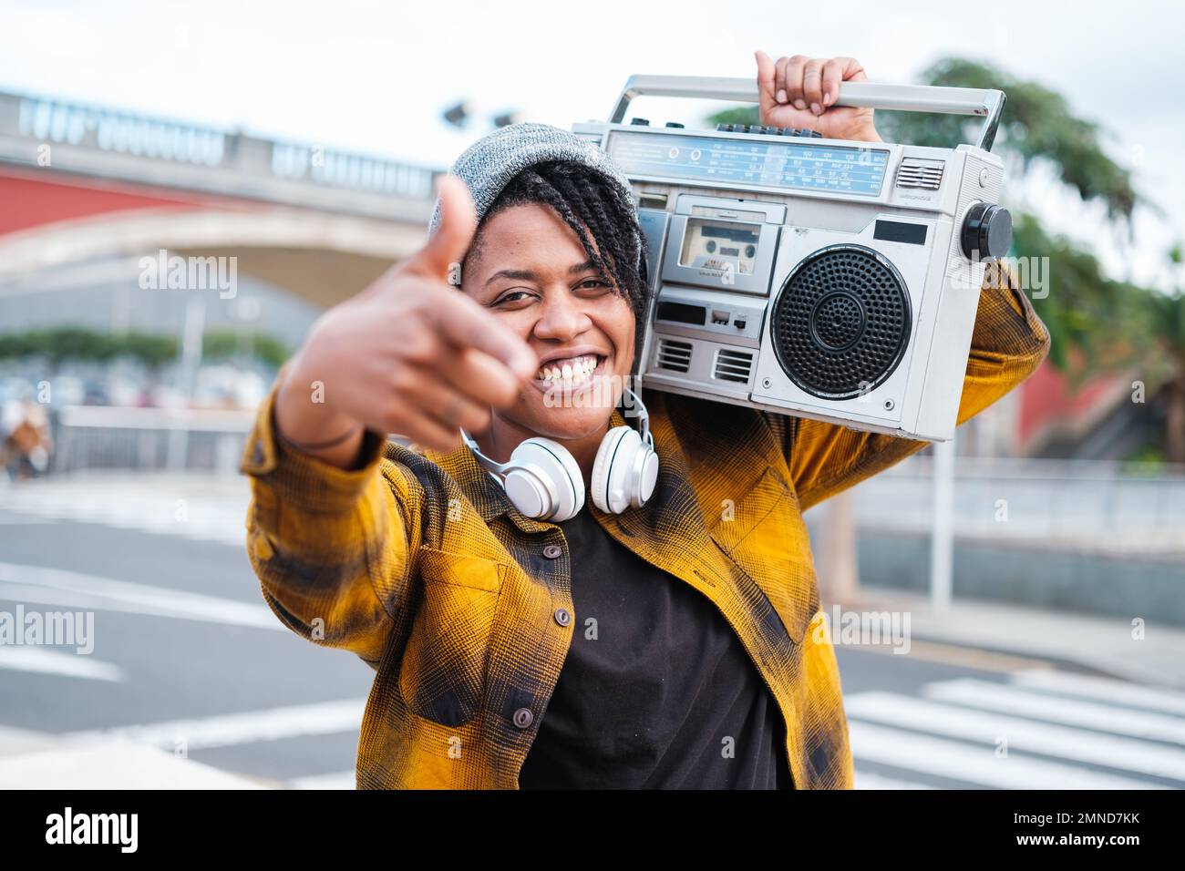 Woman singing hip-hop with the radio casstte on her shoulder to rhyme ...