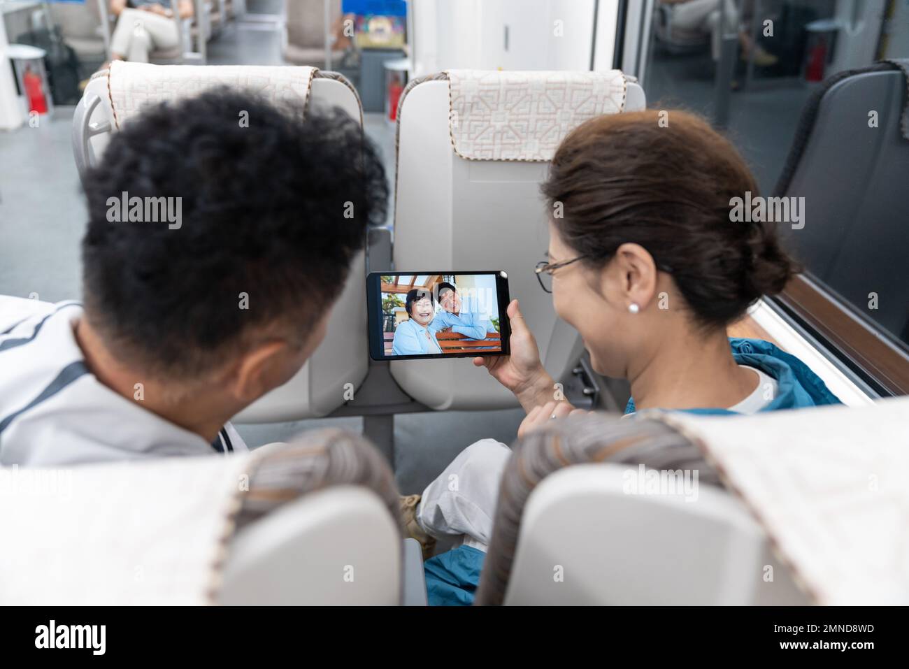 Happy elderly couple use tablet computers on the subway Stock Photo - Alamy