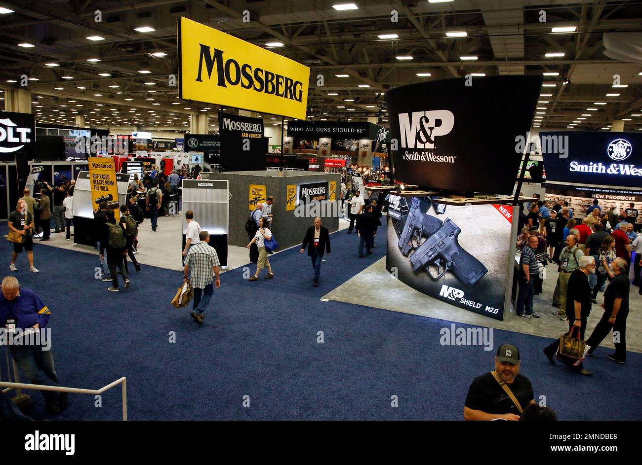 National Rifle Association convention goers walk by displays on the ...