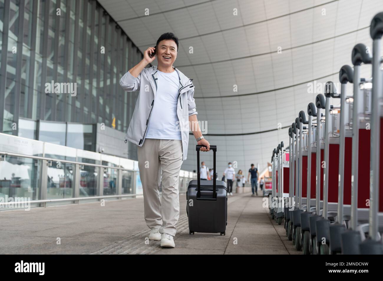 Older men pull a trunk call at the airport Stock Photo - Alamy