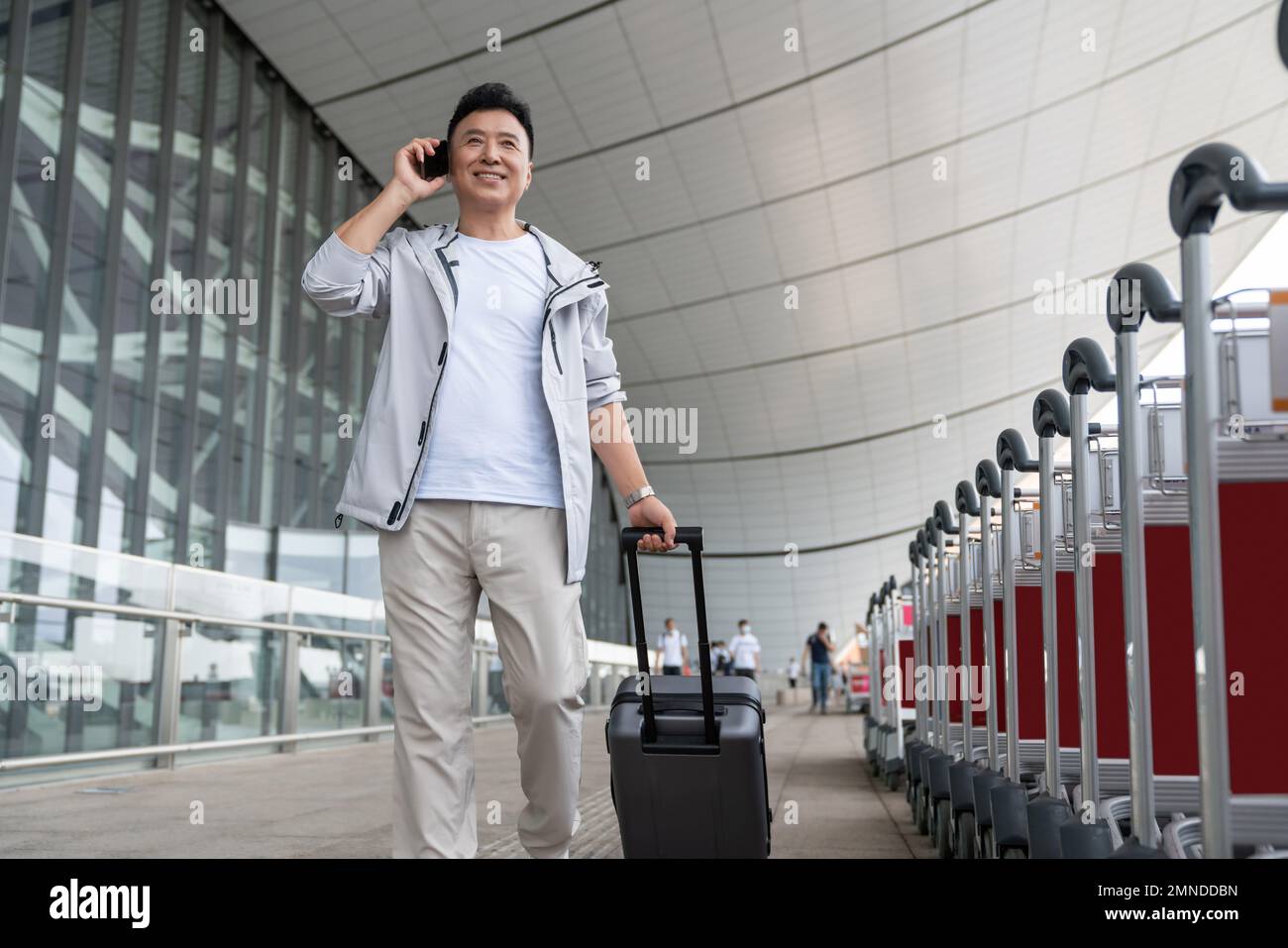 Older men pull a trunk call at the airport Stock Photo - Alamy