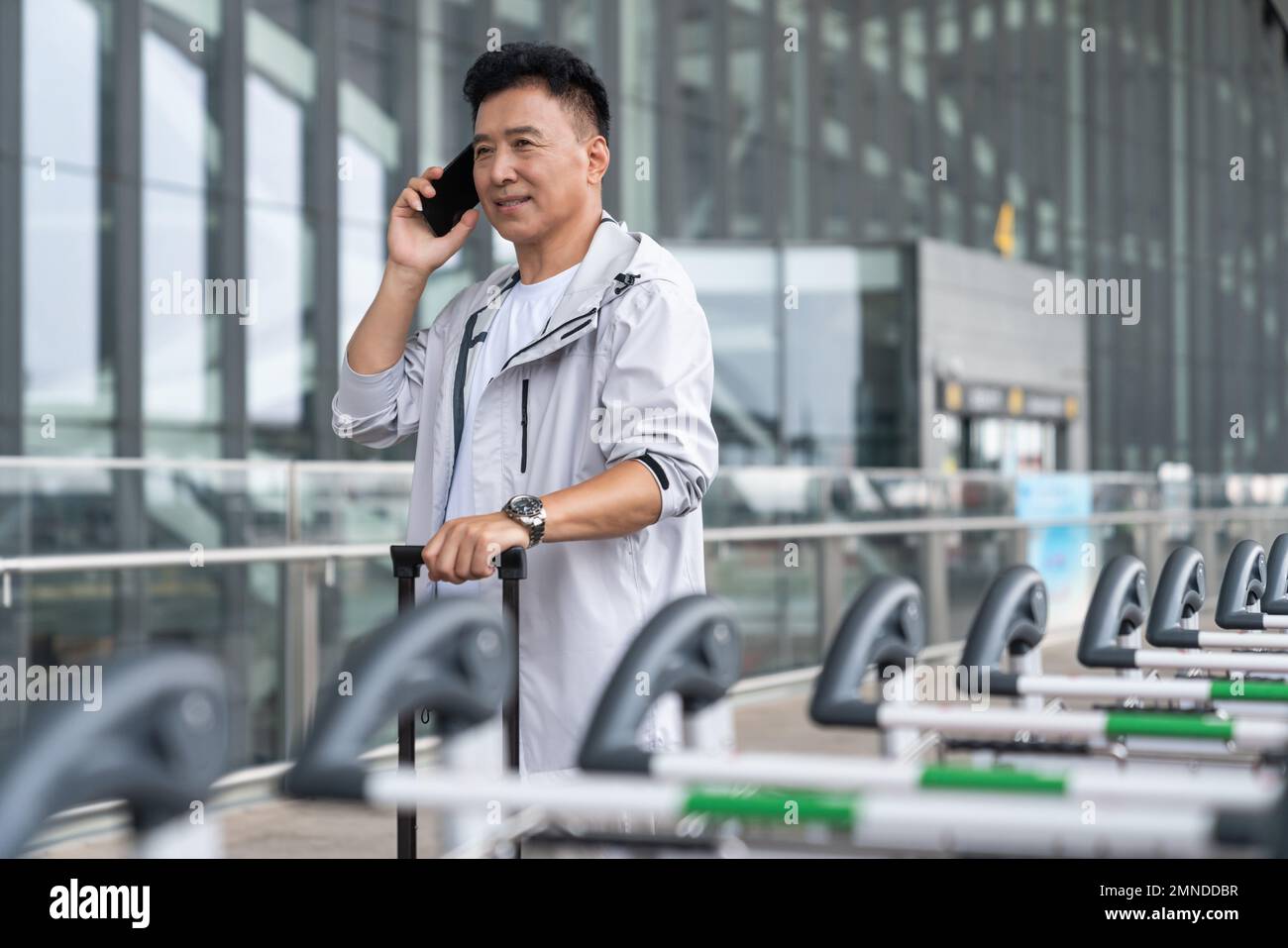 Older men pull a trunk call at the airport Stock Photo - Alamy