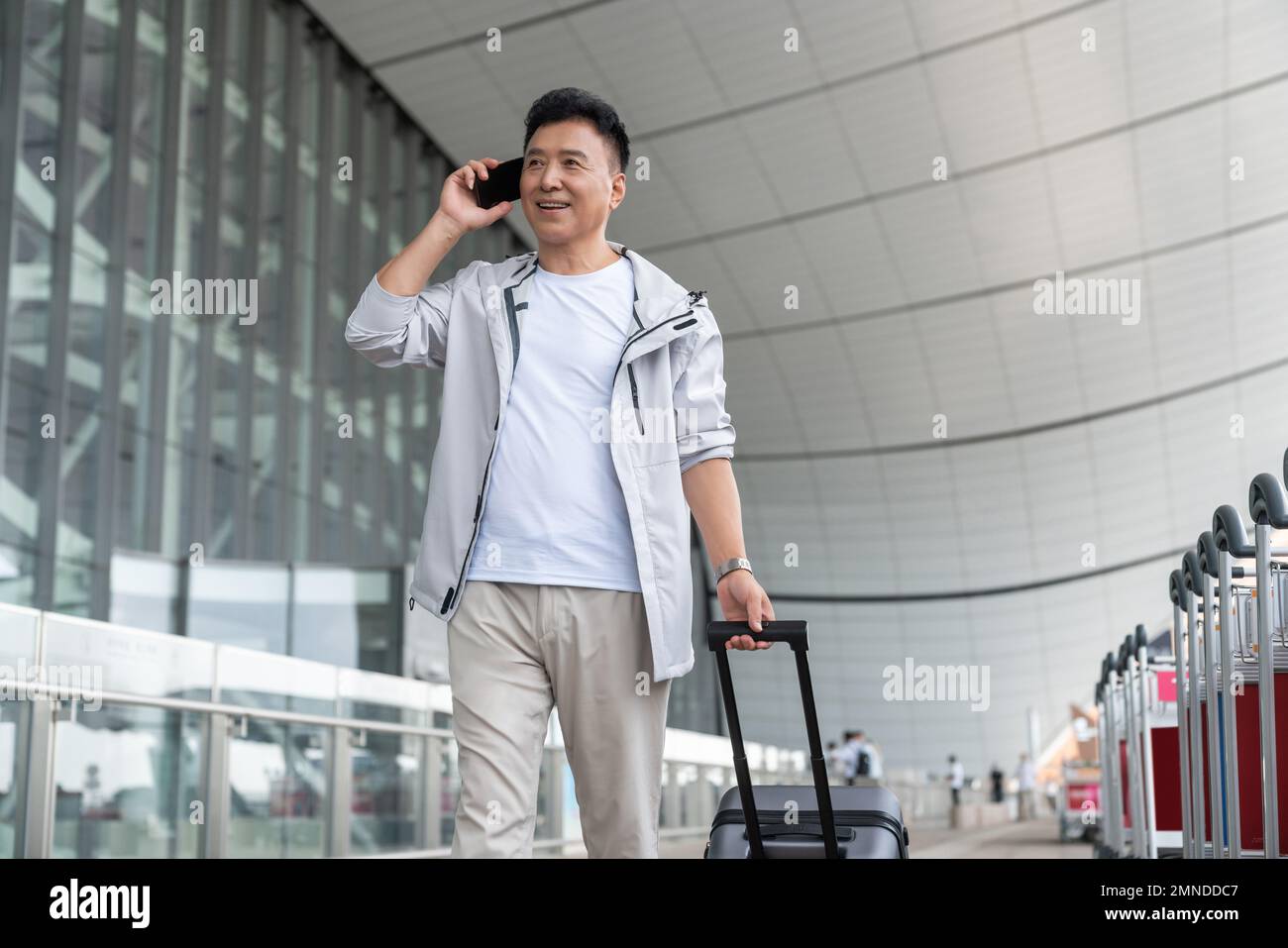 Older men pull a trunk call at the airport Stock Photo - Alamy