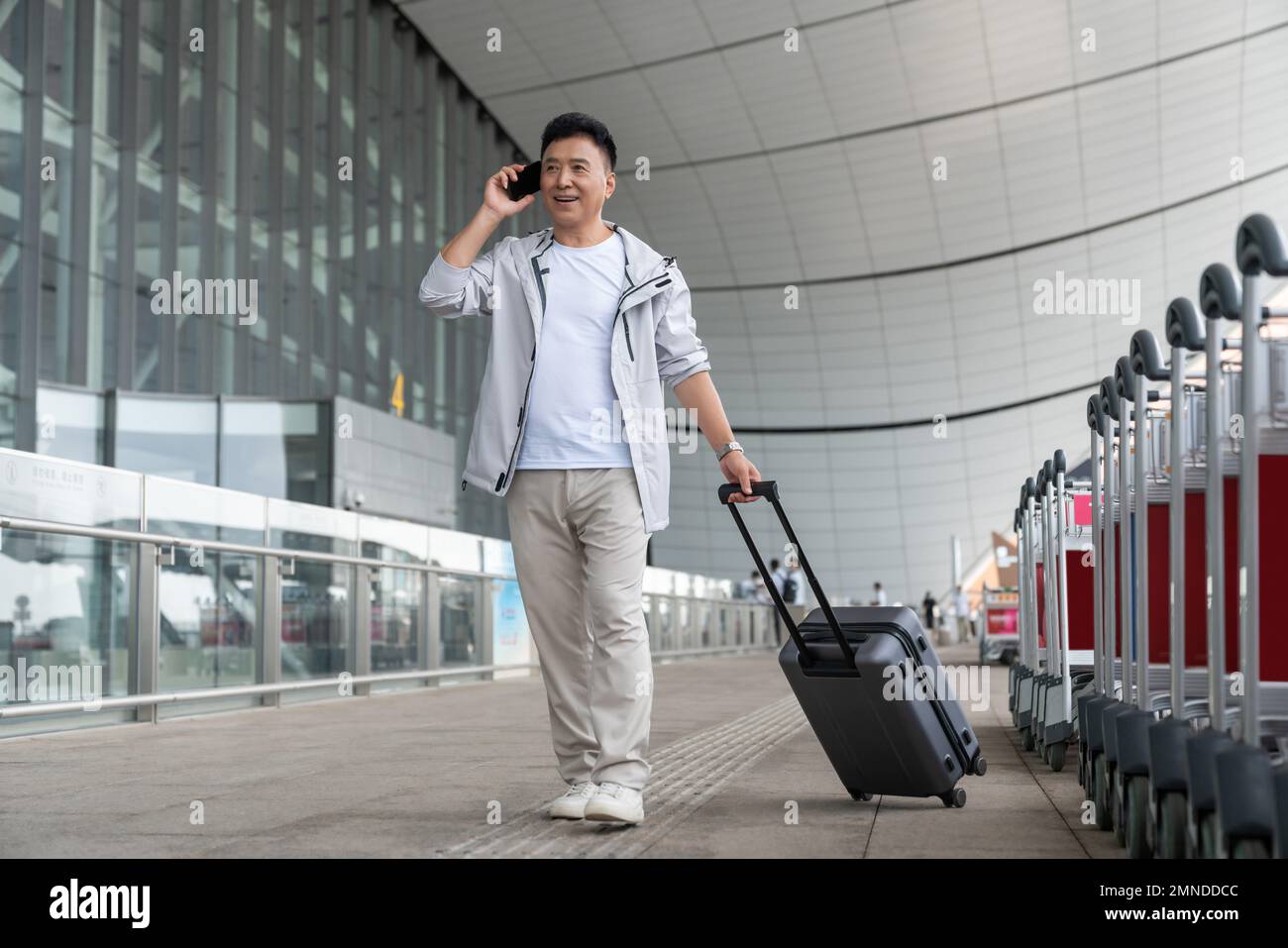 Older men pull a trunk call at the airport Stock Photo - Alamy