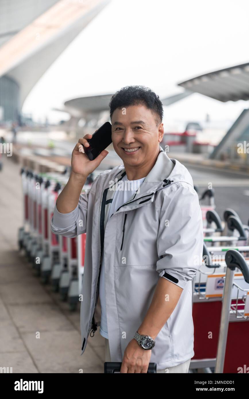 Older men pull a trunk call at the airport Stock Photo - Alamy