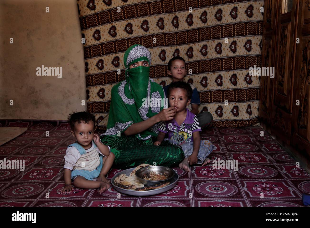 In this Feb. 11, 2018 photo, Sherine, feeds her children scraps of ...