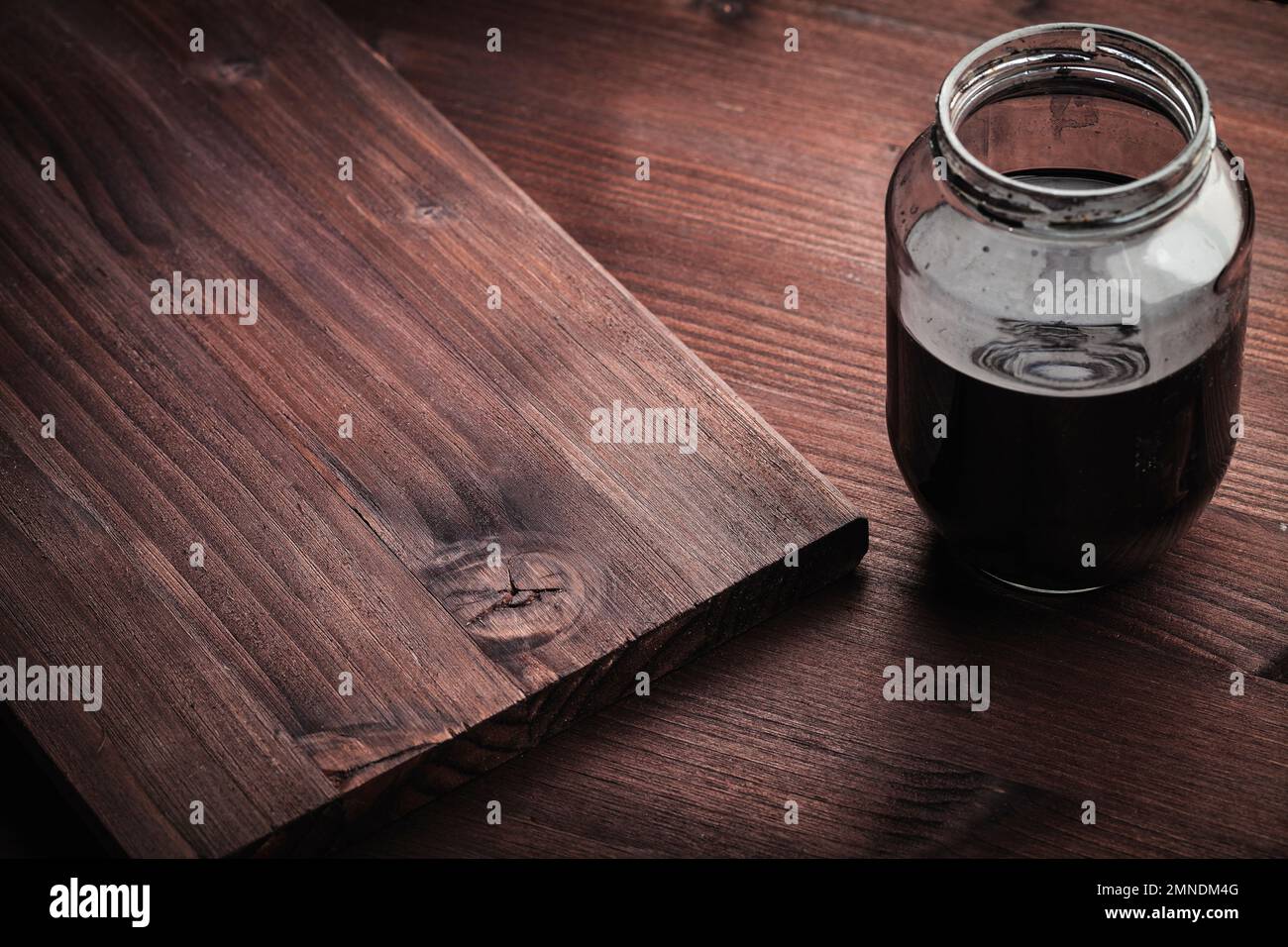Colored paint in a glass container, ready to be used as a wood stain ...