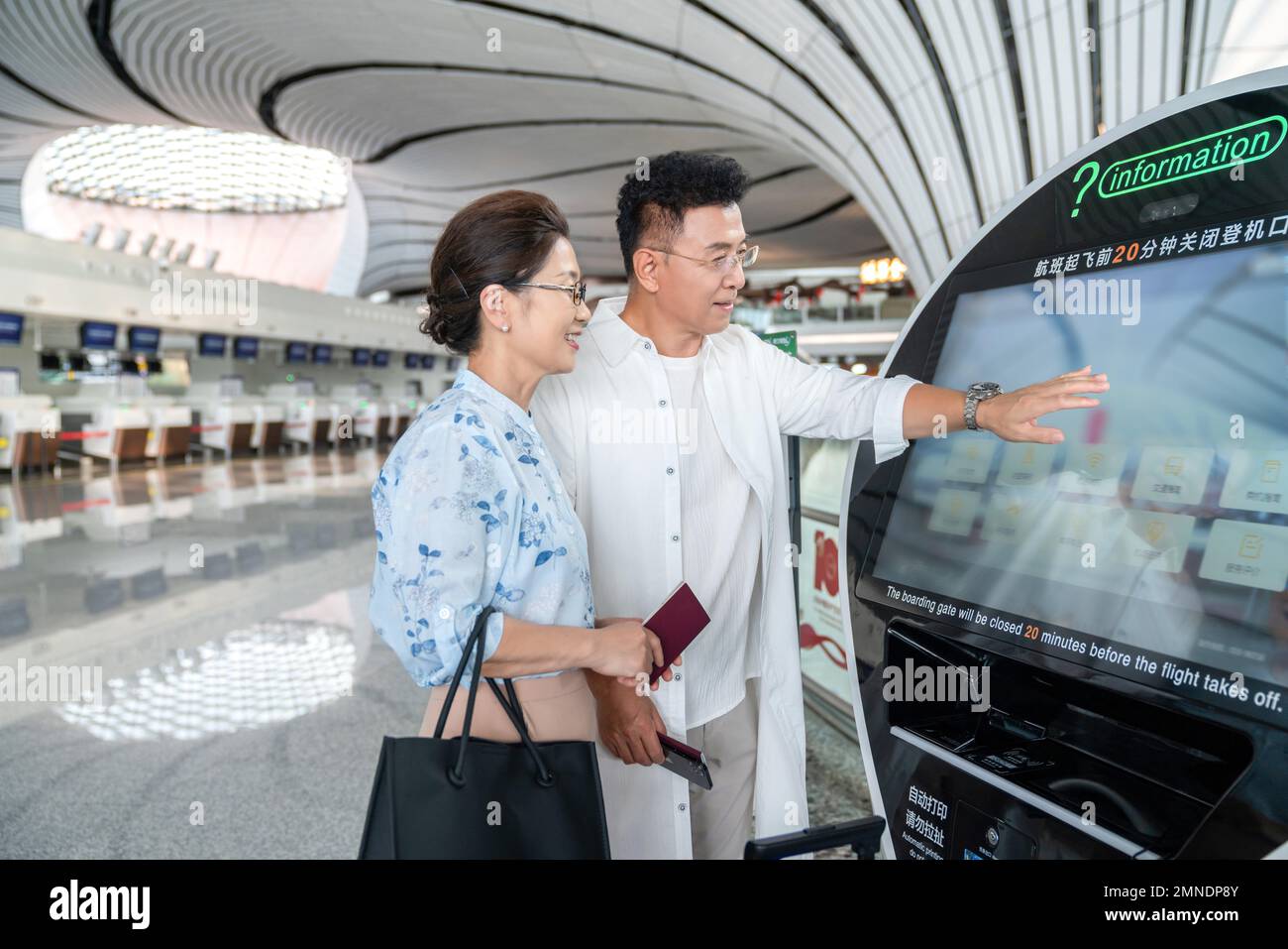 Happy elderly couple self-service ticket at the airport Stock Photo - Alamy