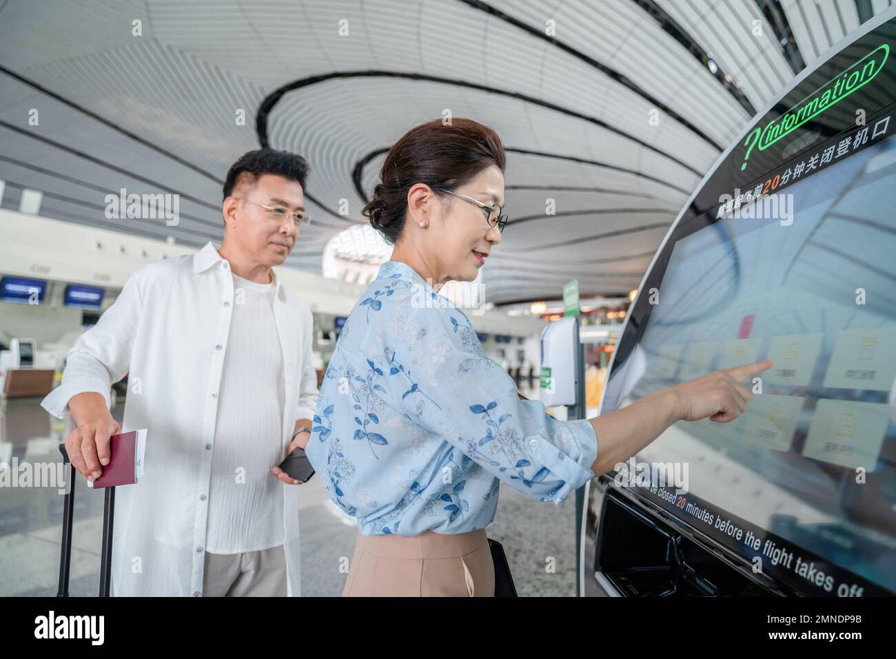 Happy elderly couple self-service ticket at the airport Stock Photo - Alamy