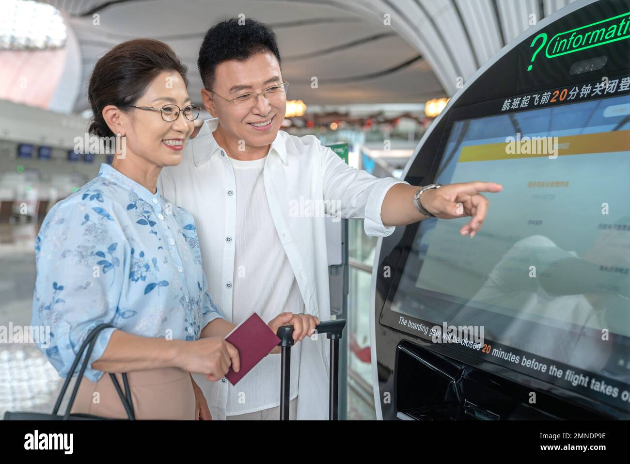 Happy elderly couple self-service ticket at the airport Stock Photo - Alamy