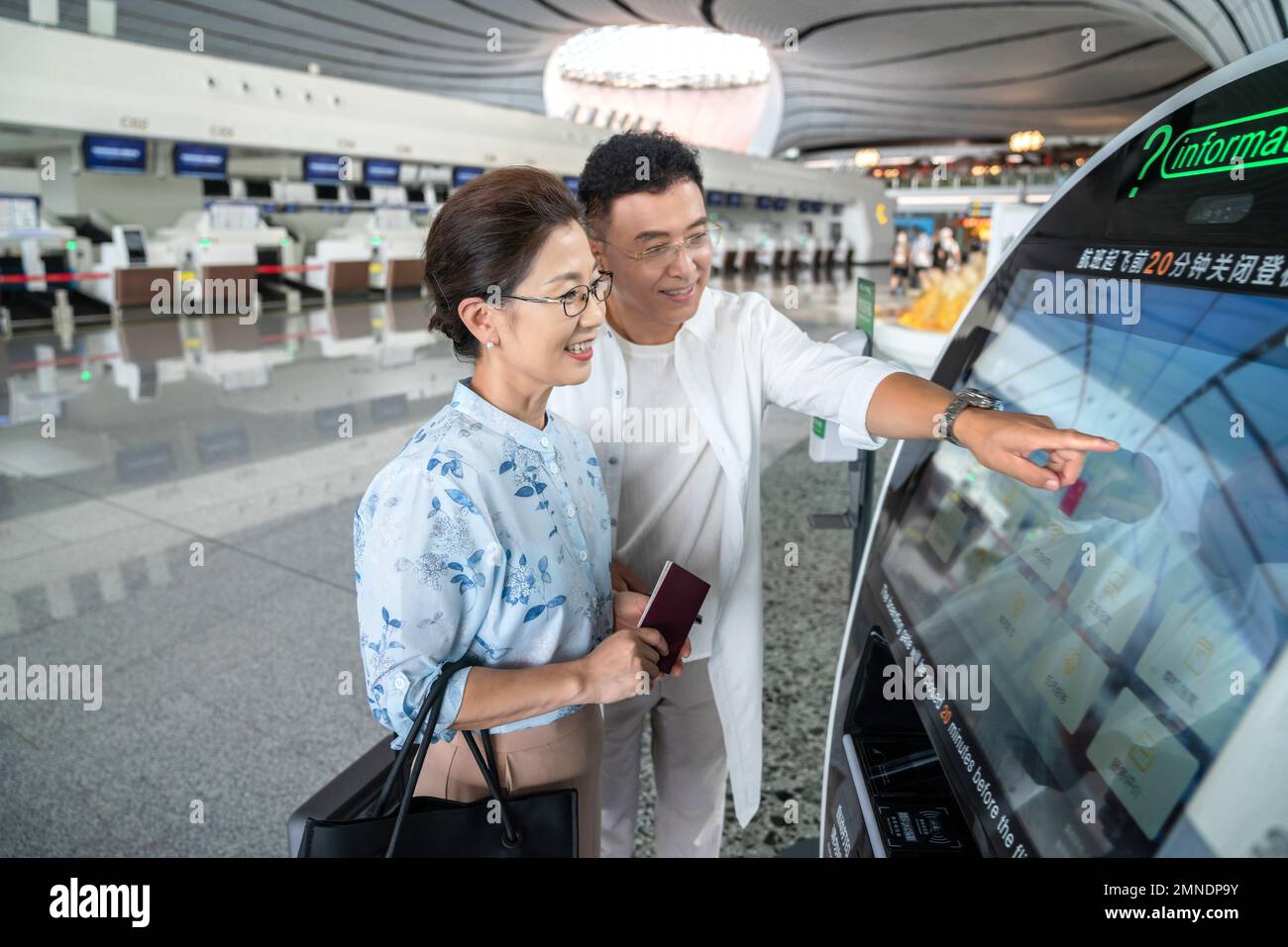 Happy elderly couple self-service ticket at the airport Stock Photo - Alamy