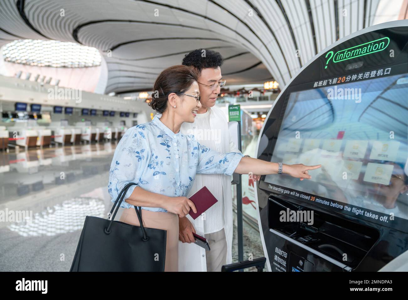 Happy elderly couple self-service ticket at the airport Stock Photo - Alamy