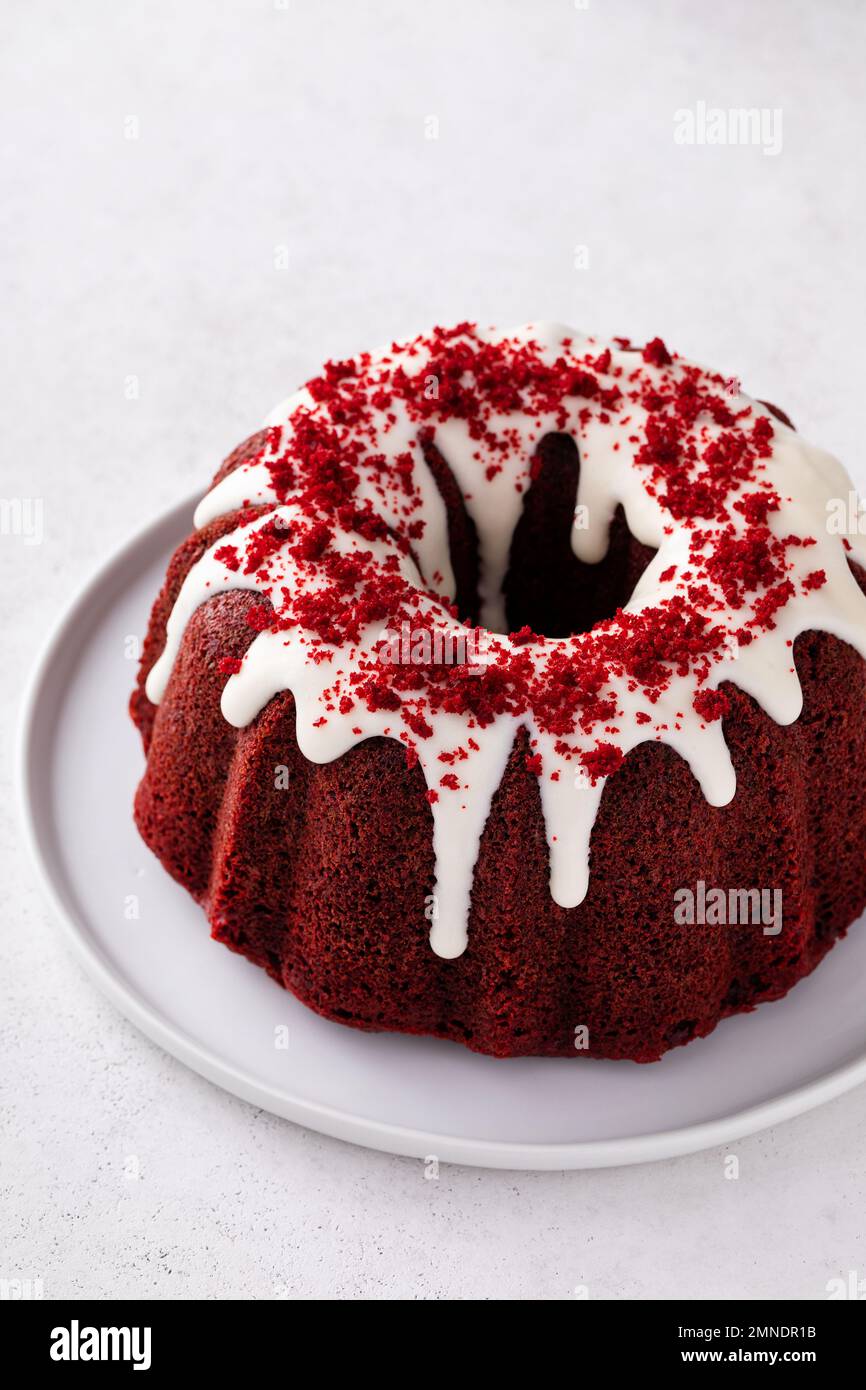 Red velvet bundt cake with cream cheese frosting and cake crumbs Stock ...
