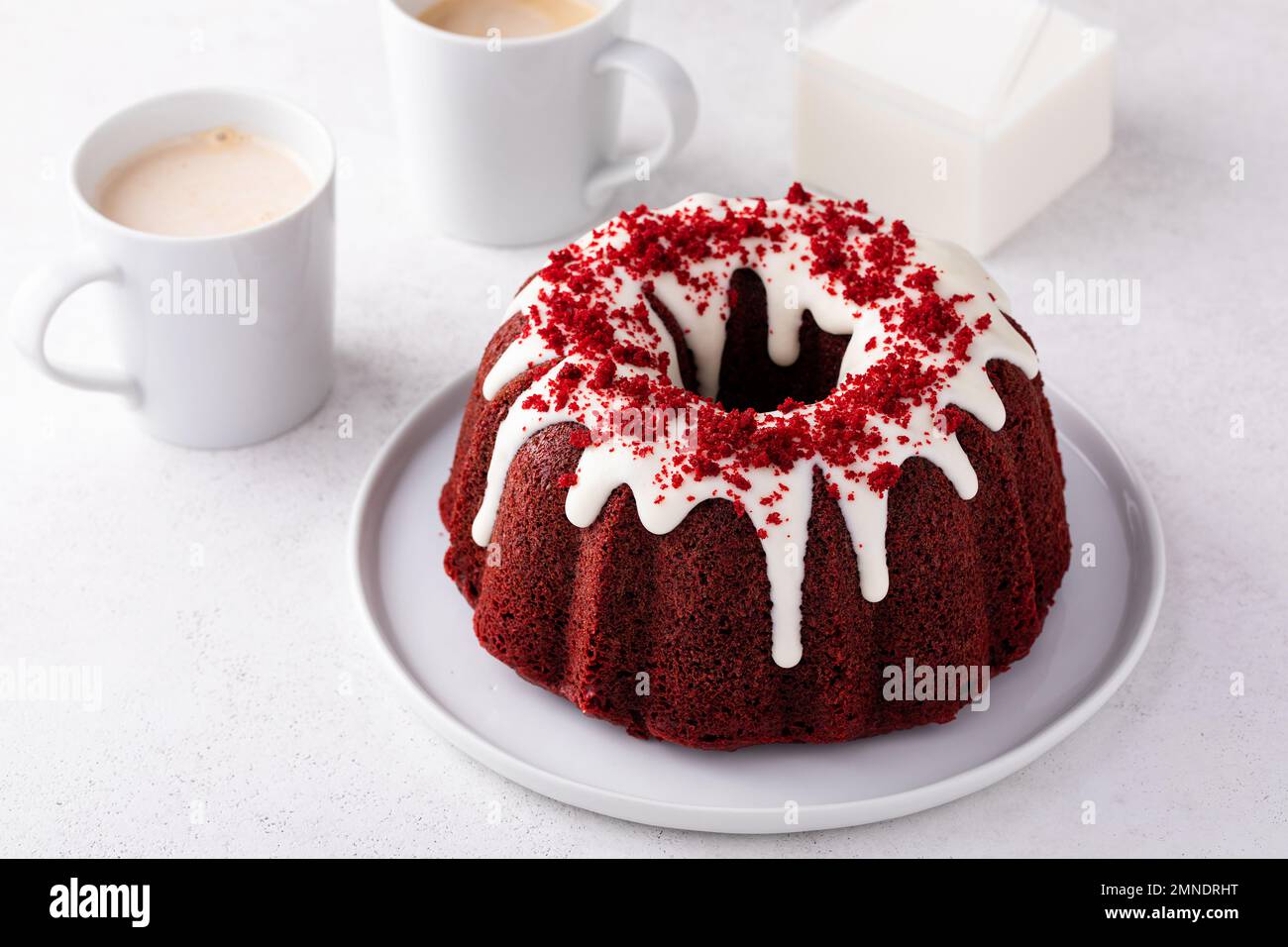 Red velvet bundt cake with cream cheese frosting and cake crumbs Stock ...