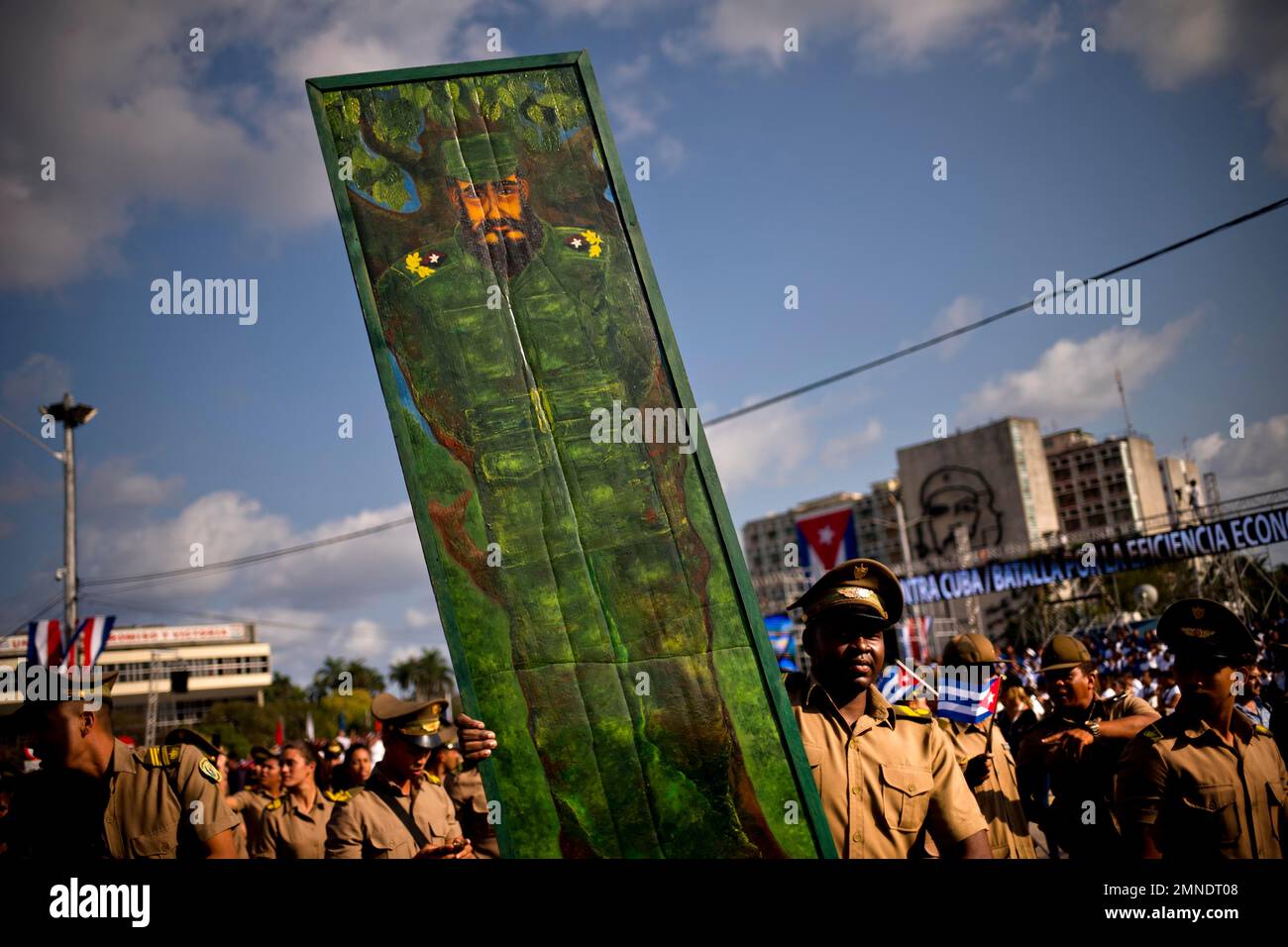 A soldier marches with a painting depicting the late Cuban leader Fidel ...