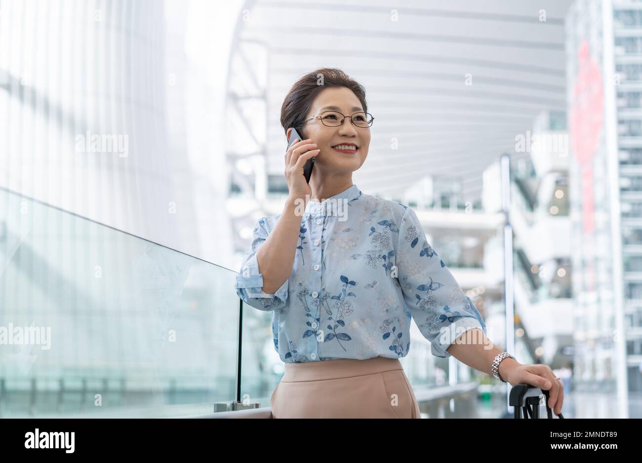 Elderly woman make a phone call at the airport Stock Photo - Alamy