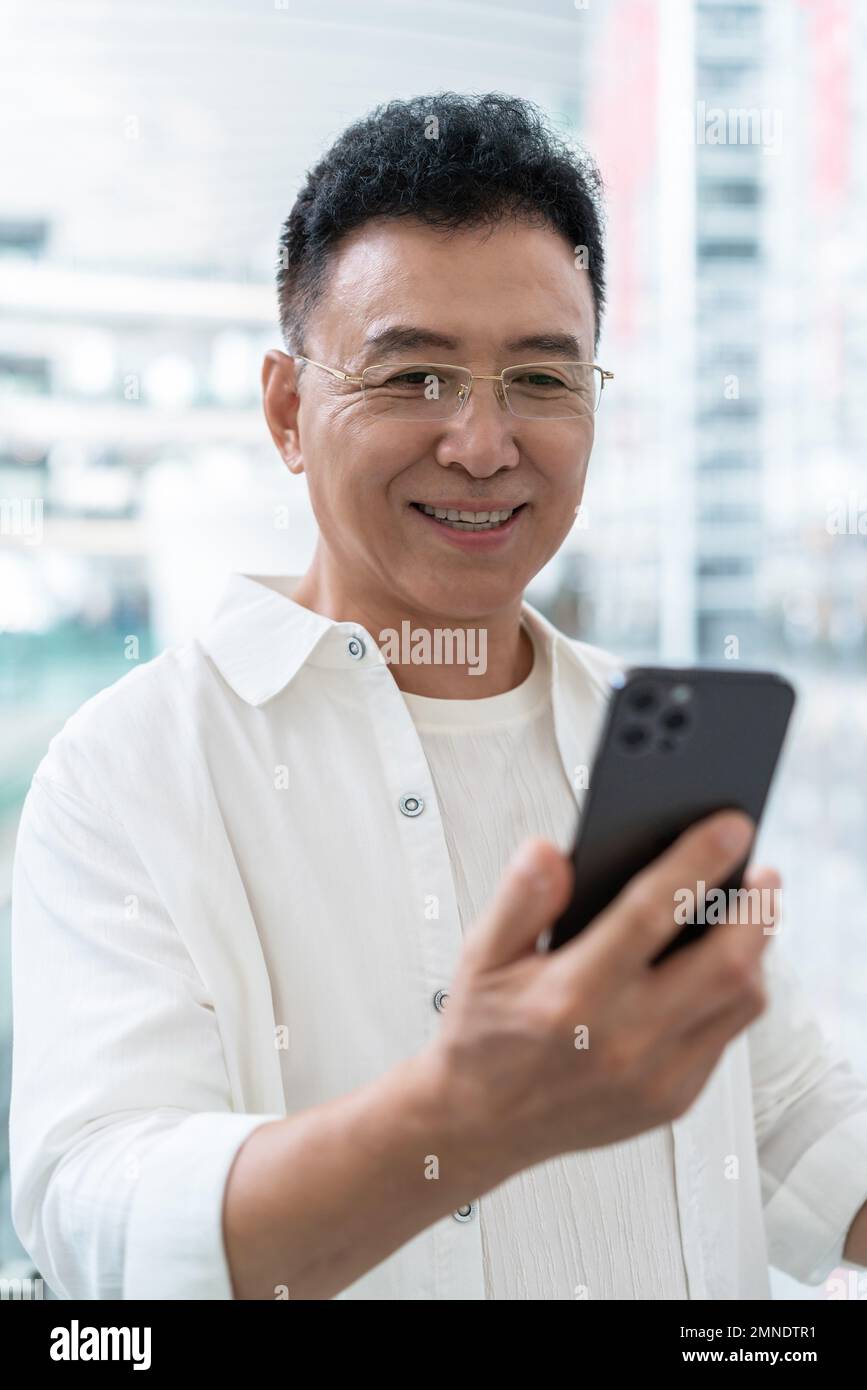 Older men use mobile phones at the airport Stock Photo - Alamy