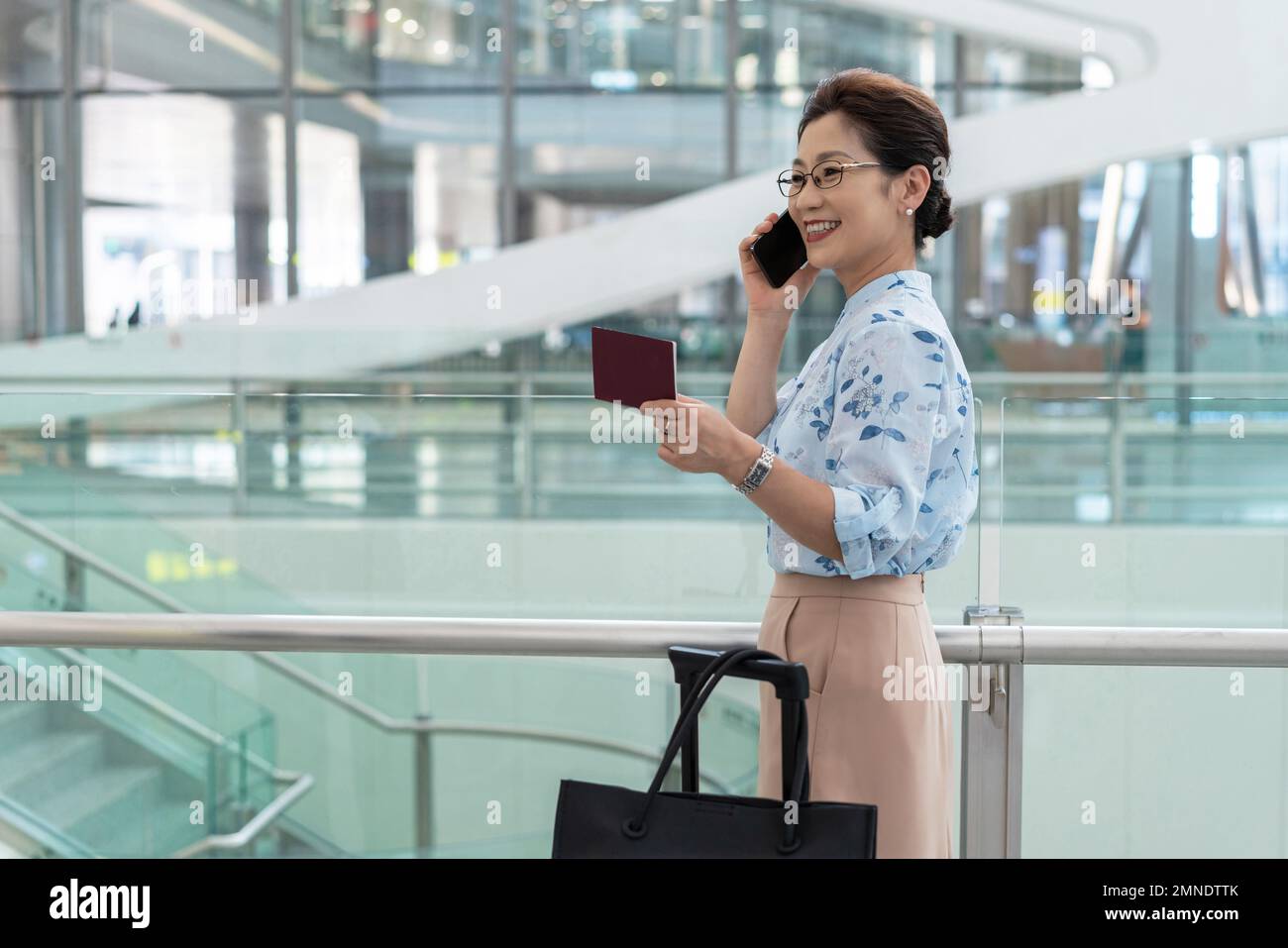 Elderly woman make a phone call at the airport Stock Photo - Alamy