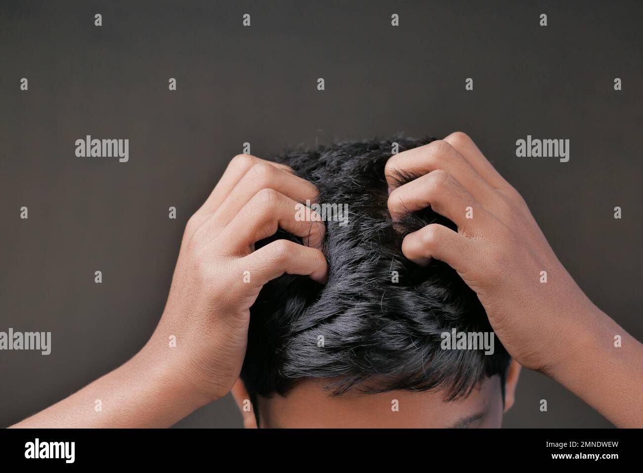teenage boy Scratching Head Against black background Stock Photo - Alamy