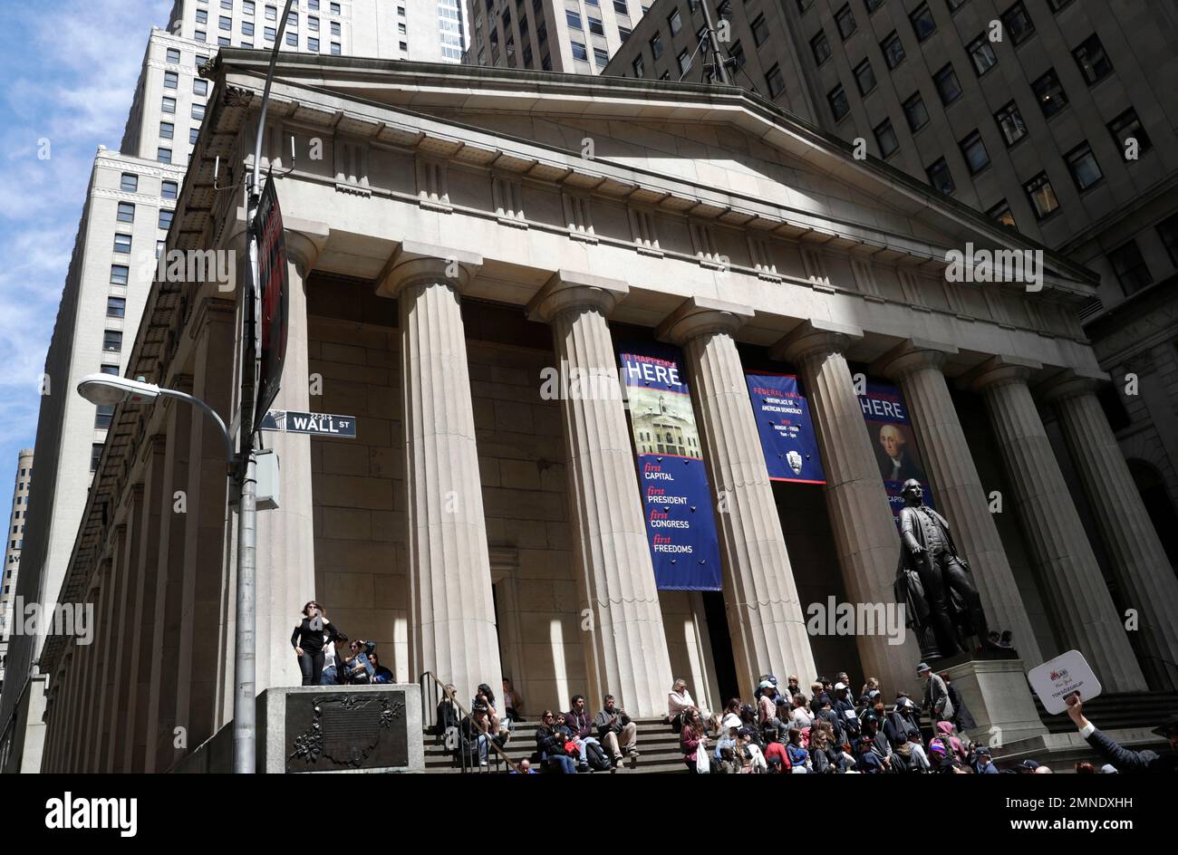 Tourists rest and enjoy the views from the steps of Federal Hall ...