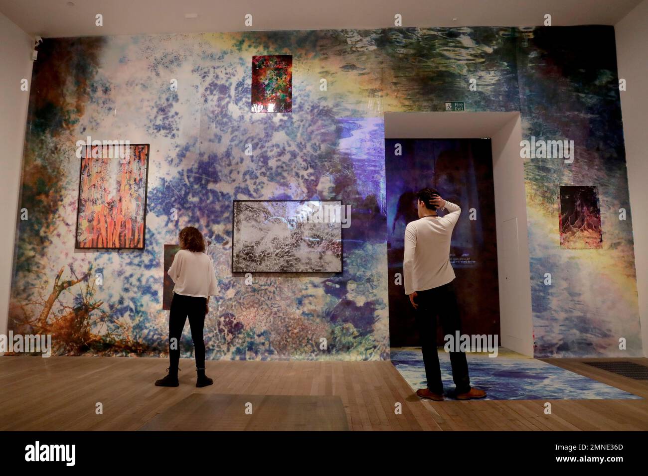 Tate staff pose for photographers in front of the installation "A Rock ...