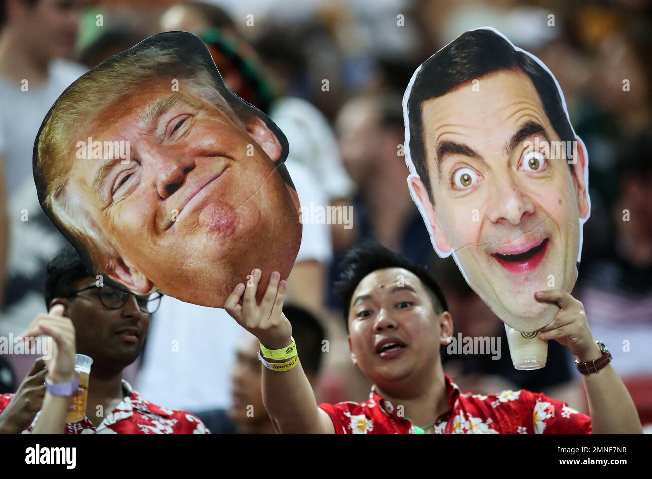 A fan holds up cutouts of U.S. President Donald Trump and "Mr Bean ...