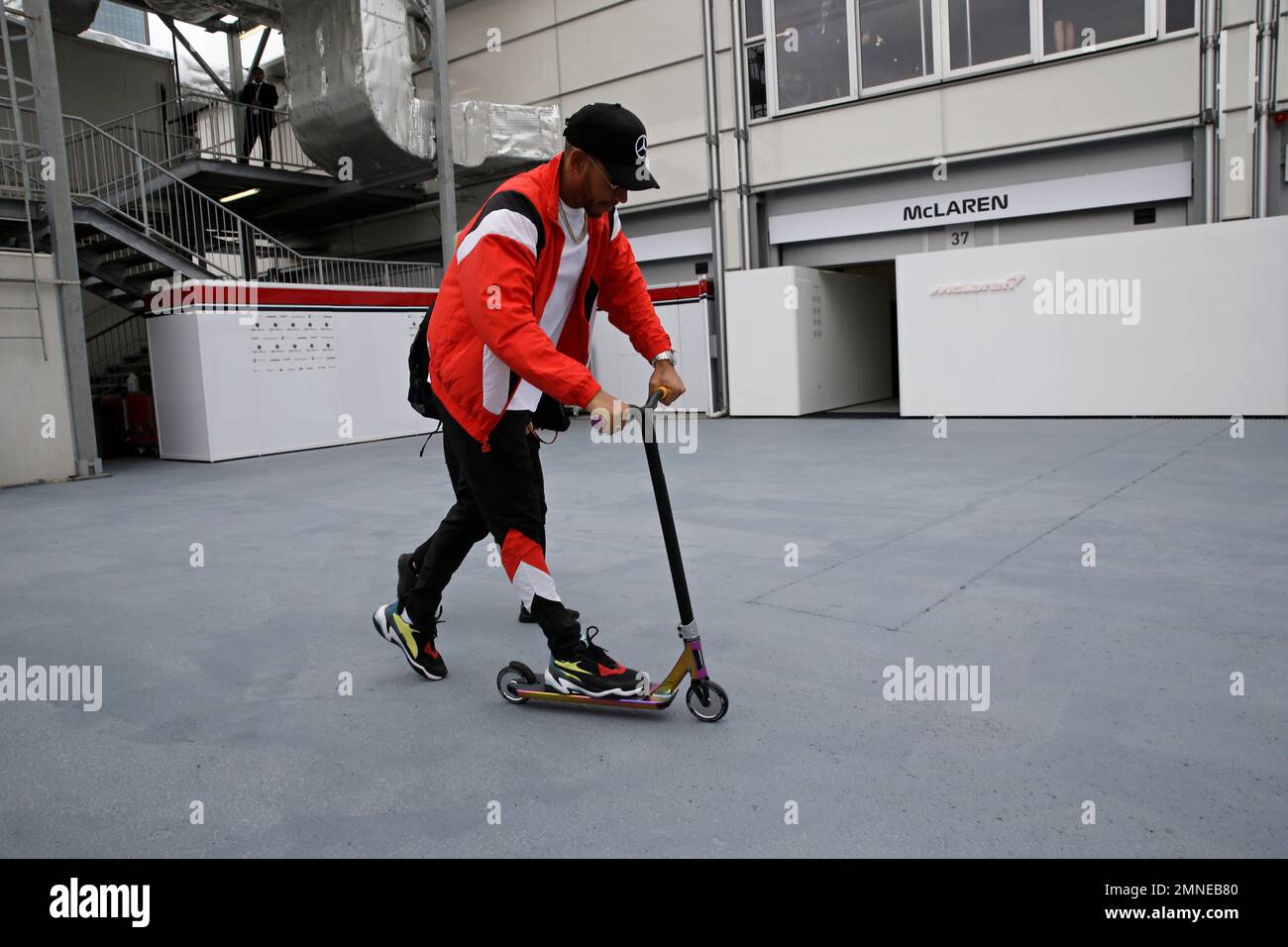 Mercedes driver Lewis Hamilton of Britain rides a scooter at the ...