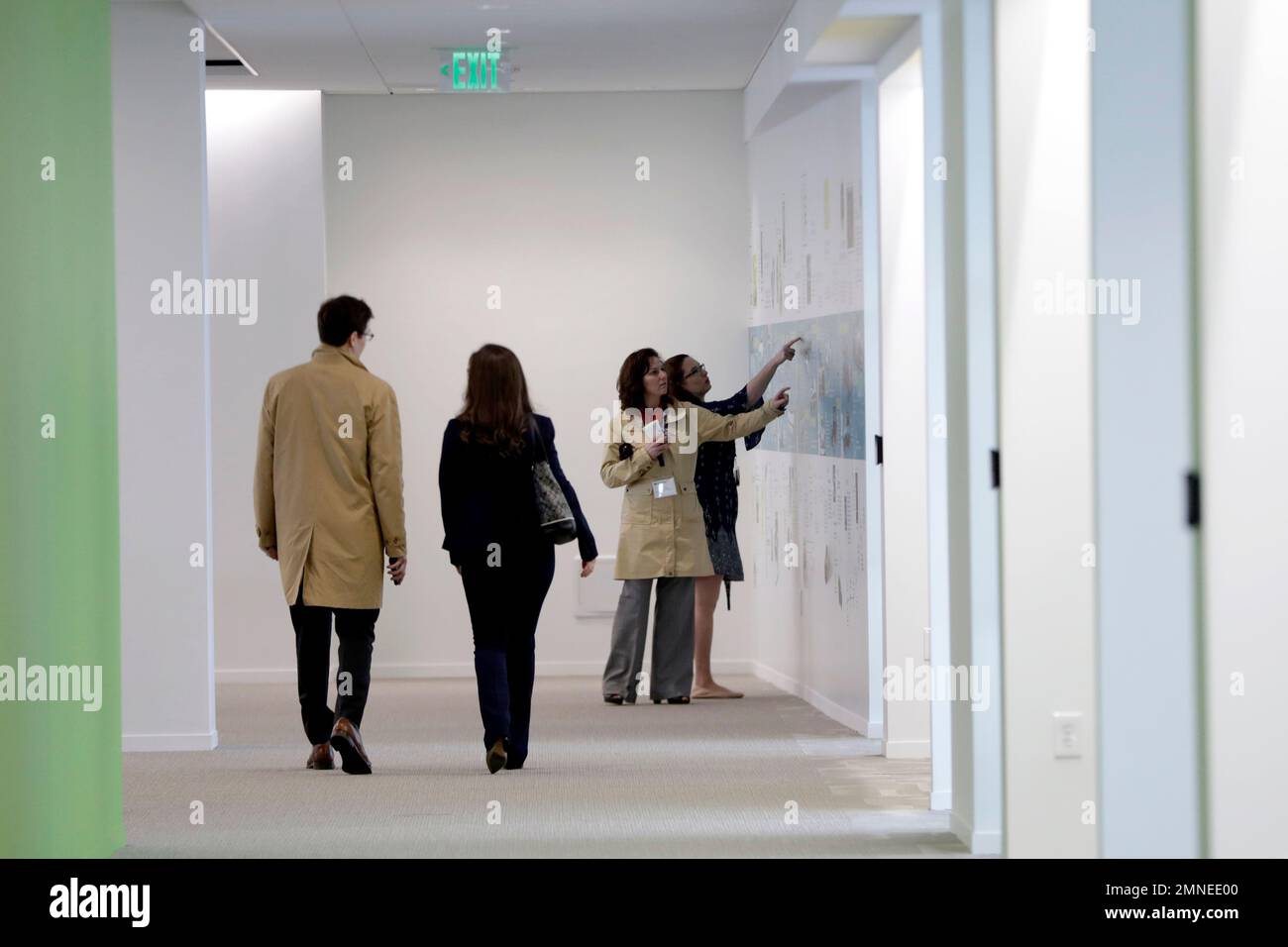 People look at a timeline posted on the wall during the grand opening ...