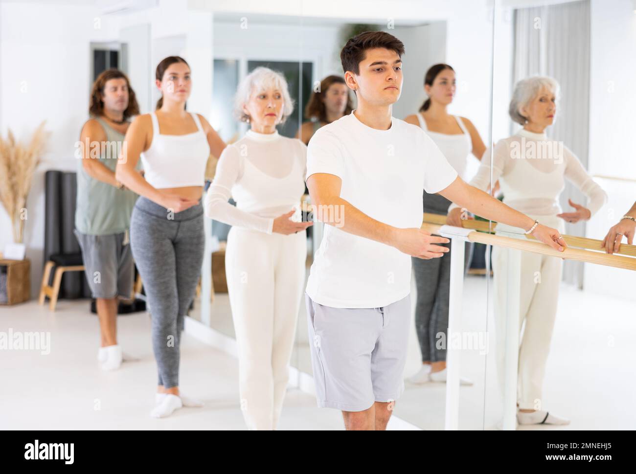 Group of different people doing ballet at barre Stock Photo - Alamy