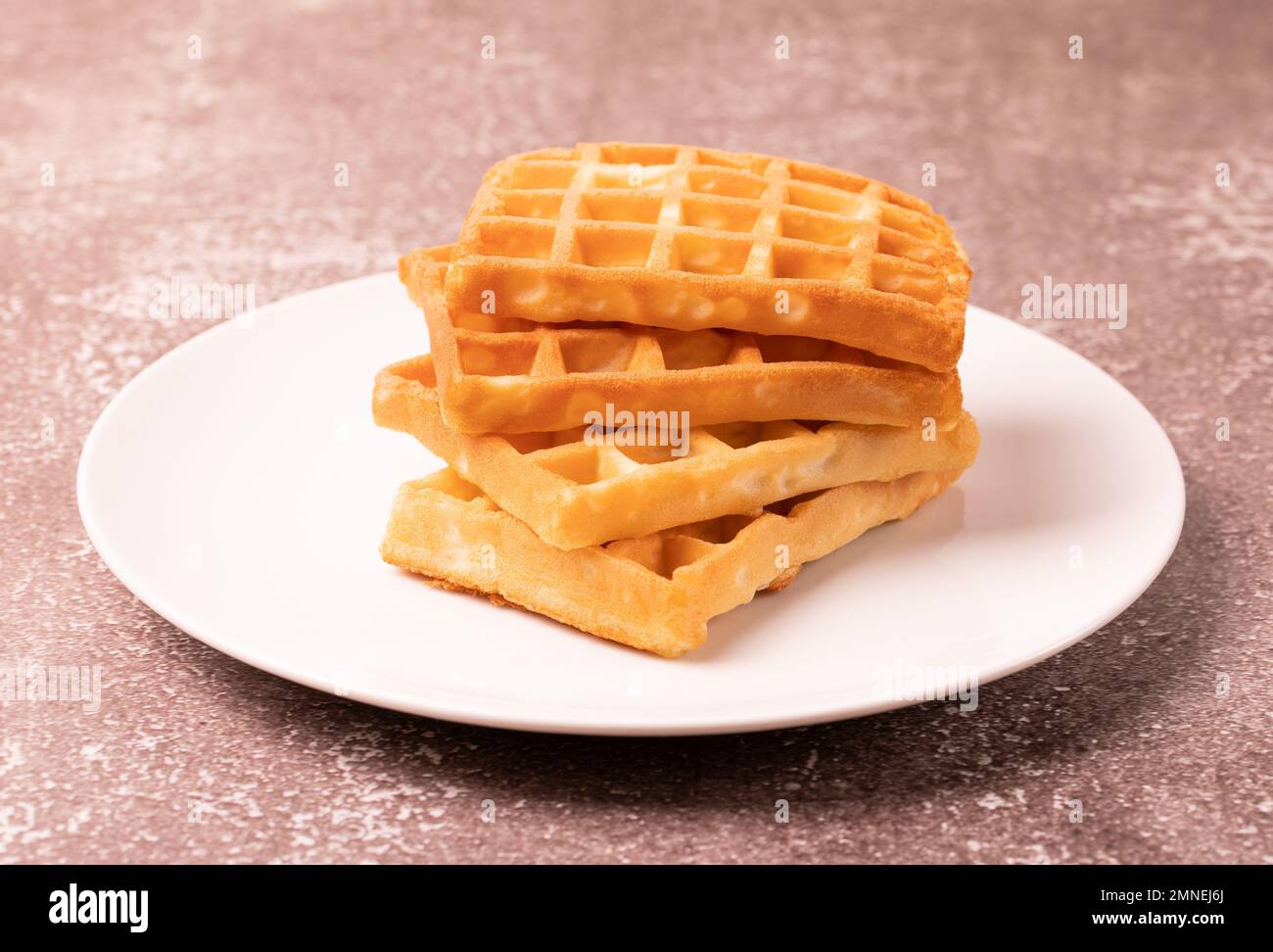 Delicious Belgian waffles with honey served on white plate and brown ...