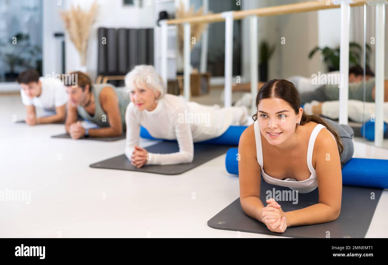 Group of different people doing exercises with roller Stock Photo - Alamy