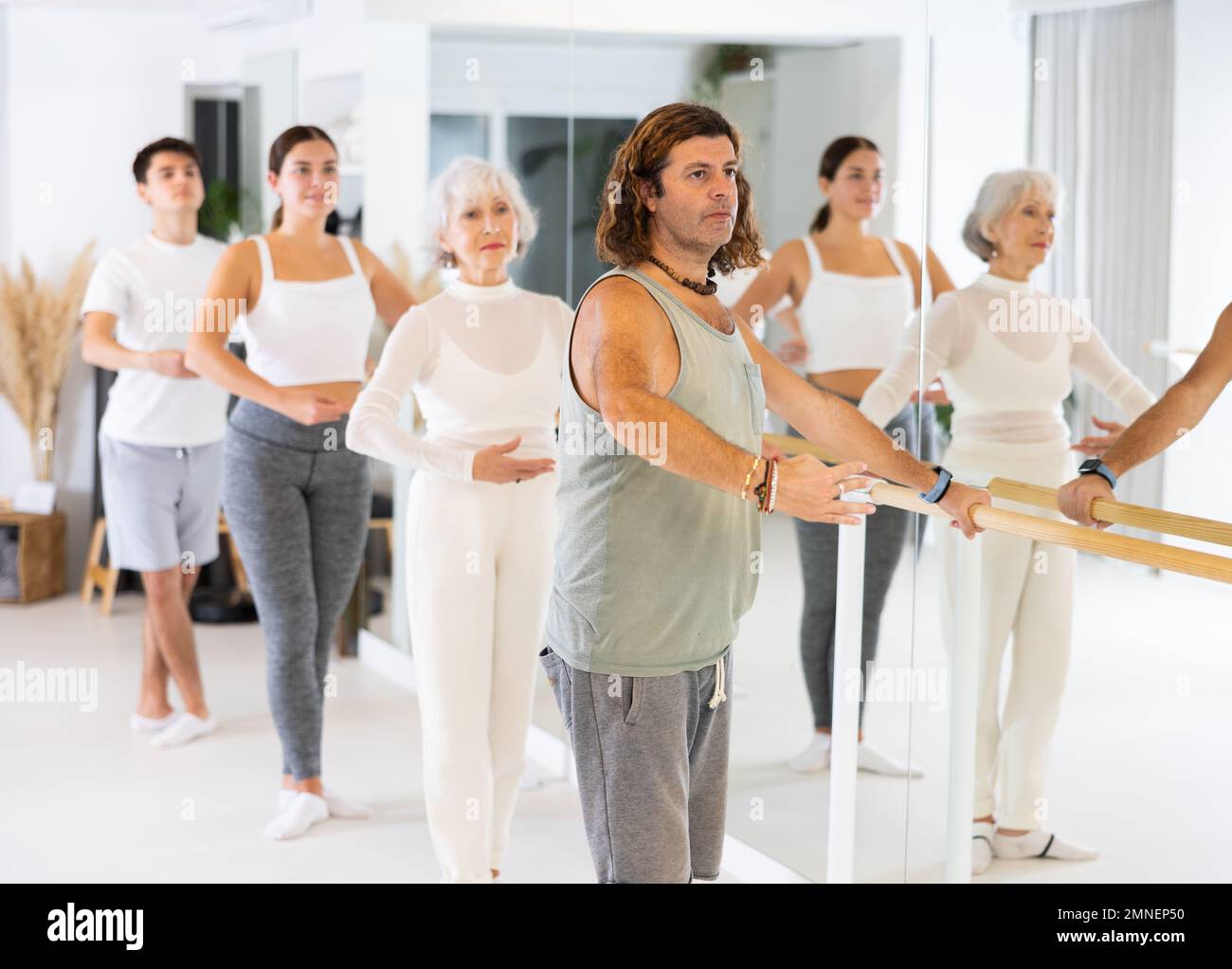 Group of different people doing ballet at barre Stock Photo - Alamy