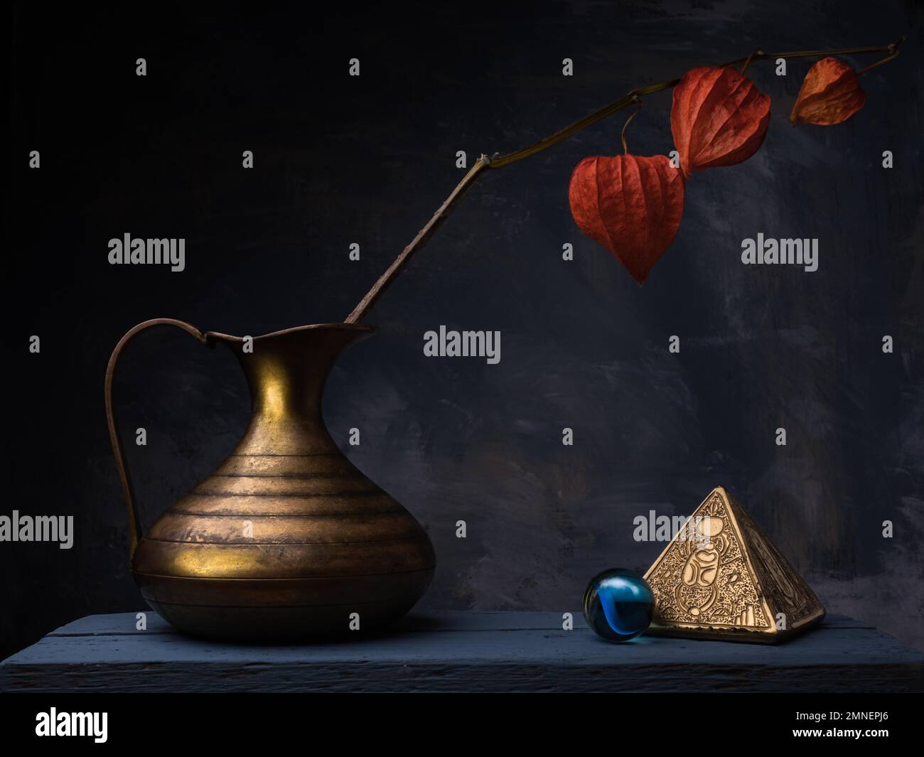 Still life with gilded pyramid, glass ball and physalis in brass vase ...