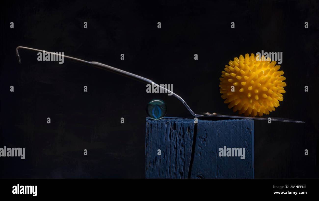 Still life with glass ball and spiked ball on spatula, studio shot ...