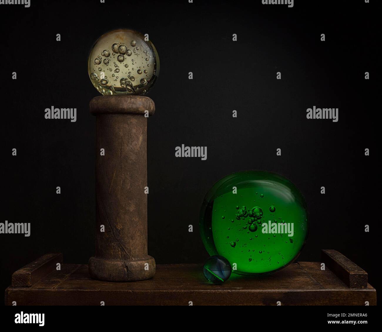Still life with glass balls and wooden spool, studio shot, dark ...