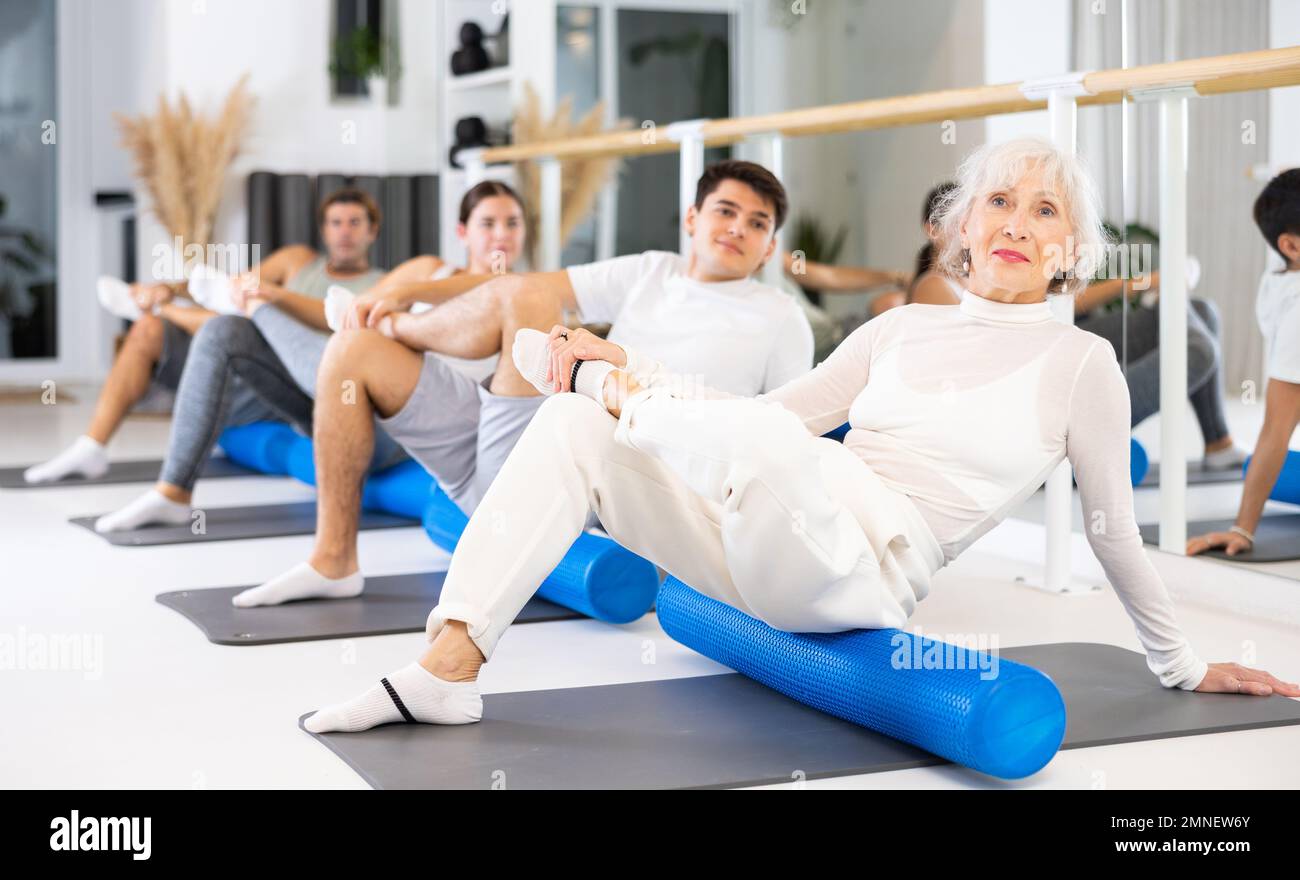 Group of different people doing exercises with roller Stock Photo - Alamy