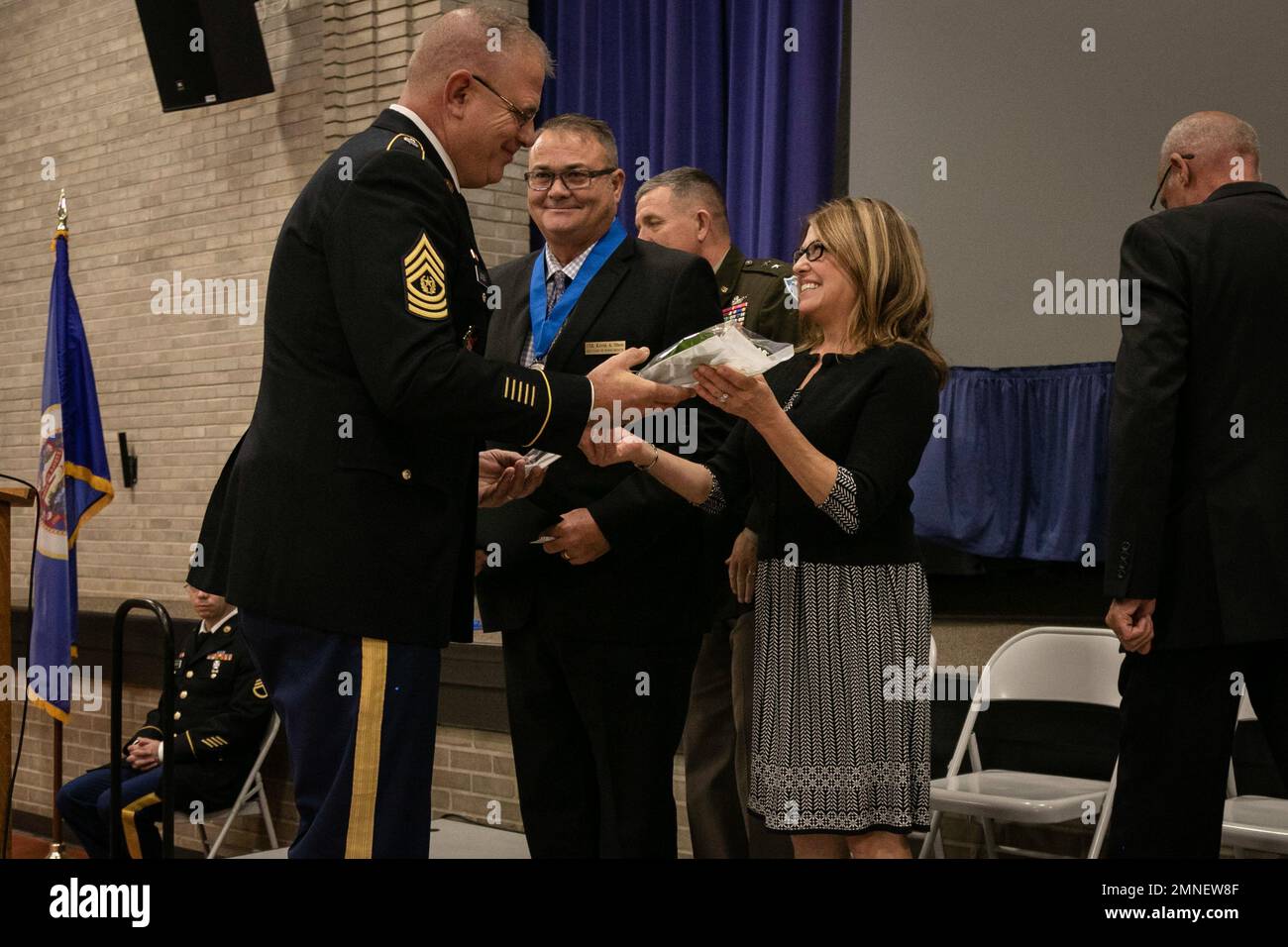 Minnesota’s Army Command Sgt. Maj. George Jensen presents a flower to ...