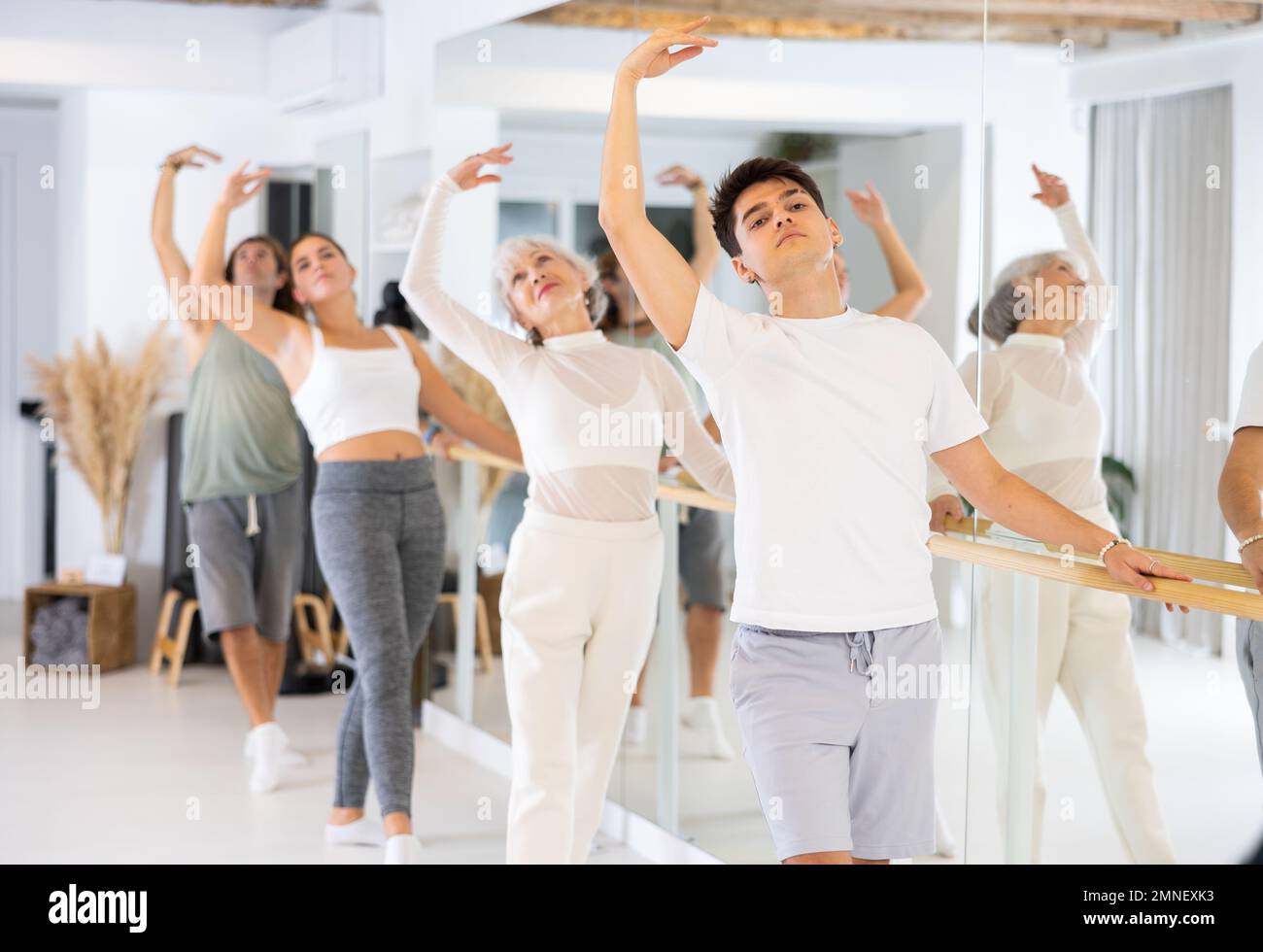 Group of different people doing ballet at barre Stock Photo - Alamy