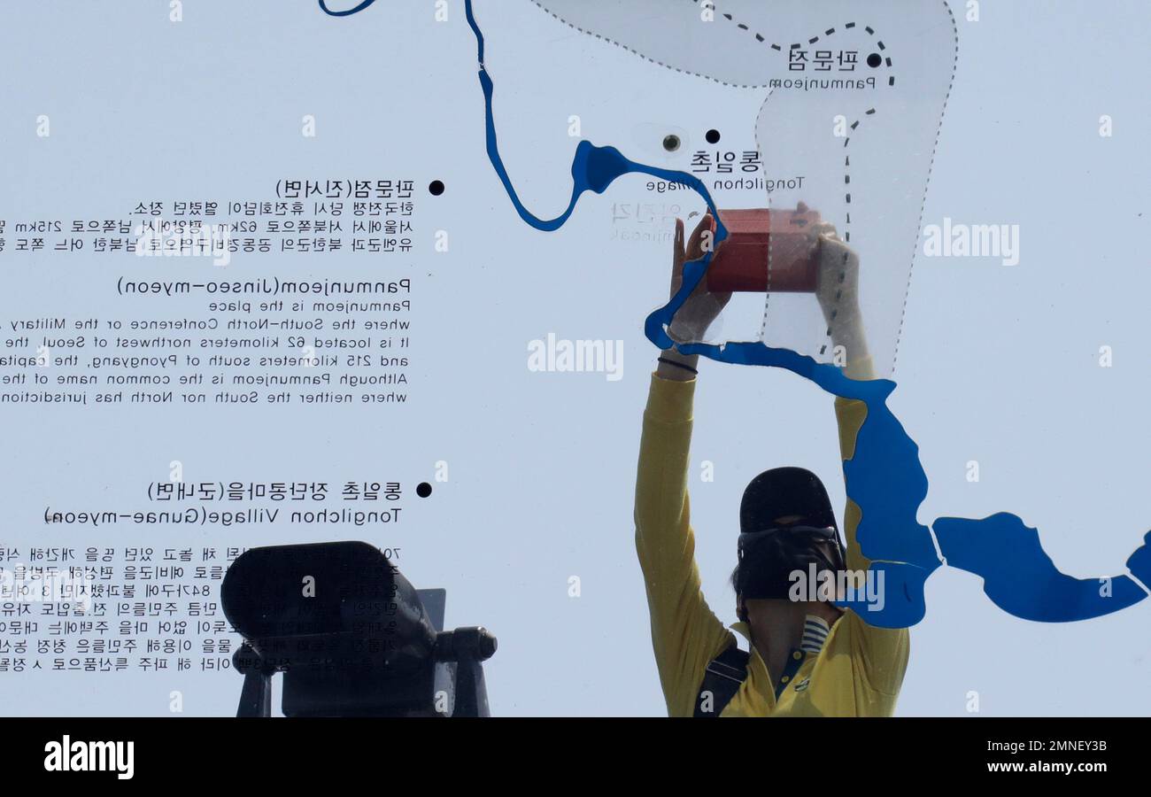 A woman uses her mobile phone to take photo of a map of Panmunjom which ...