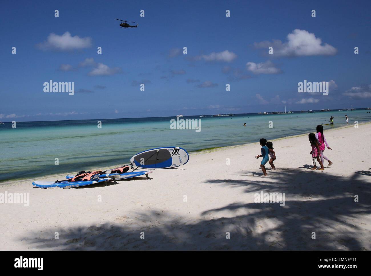 Children watch as a military helicopter passes by the country's most ...